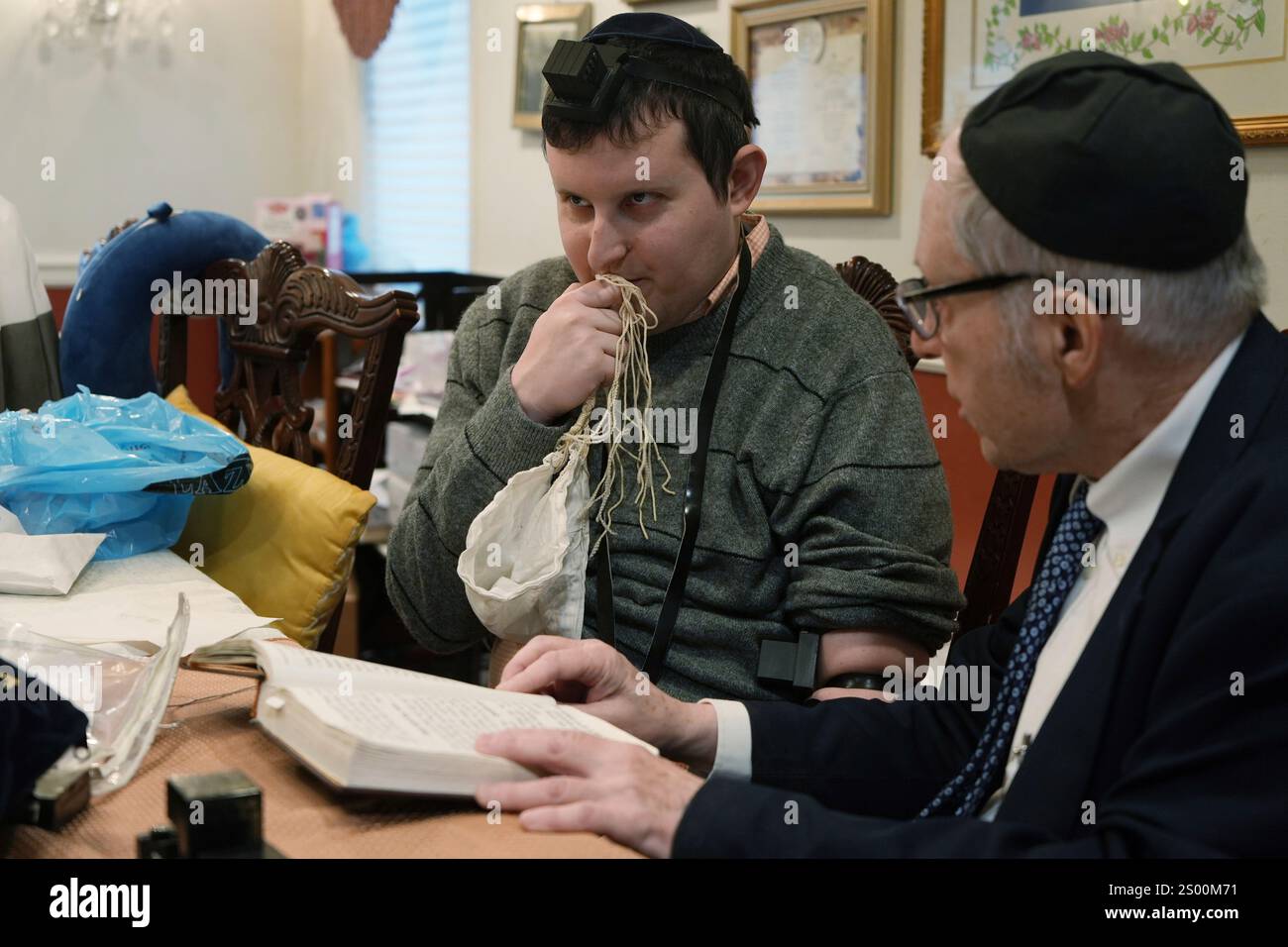 Dov Marcus, left, kisses the knotted fringes -- known as tzitzit – of ...