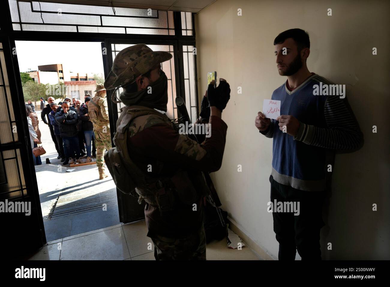 A Syrian fighter, center, takes pictures of members of ousted Syrian ...