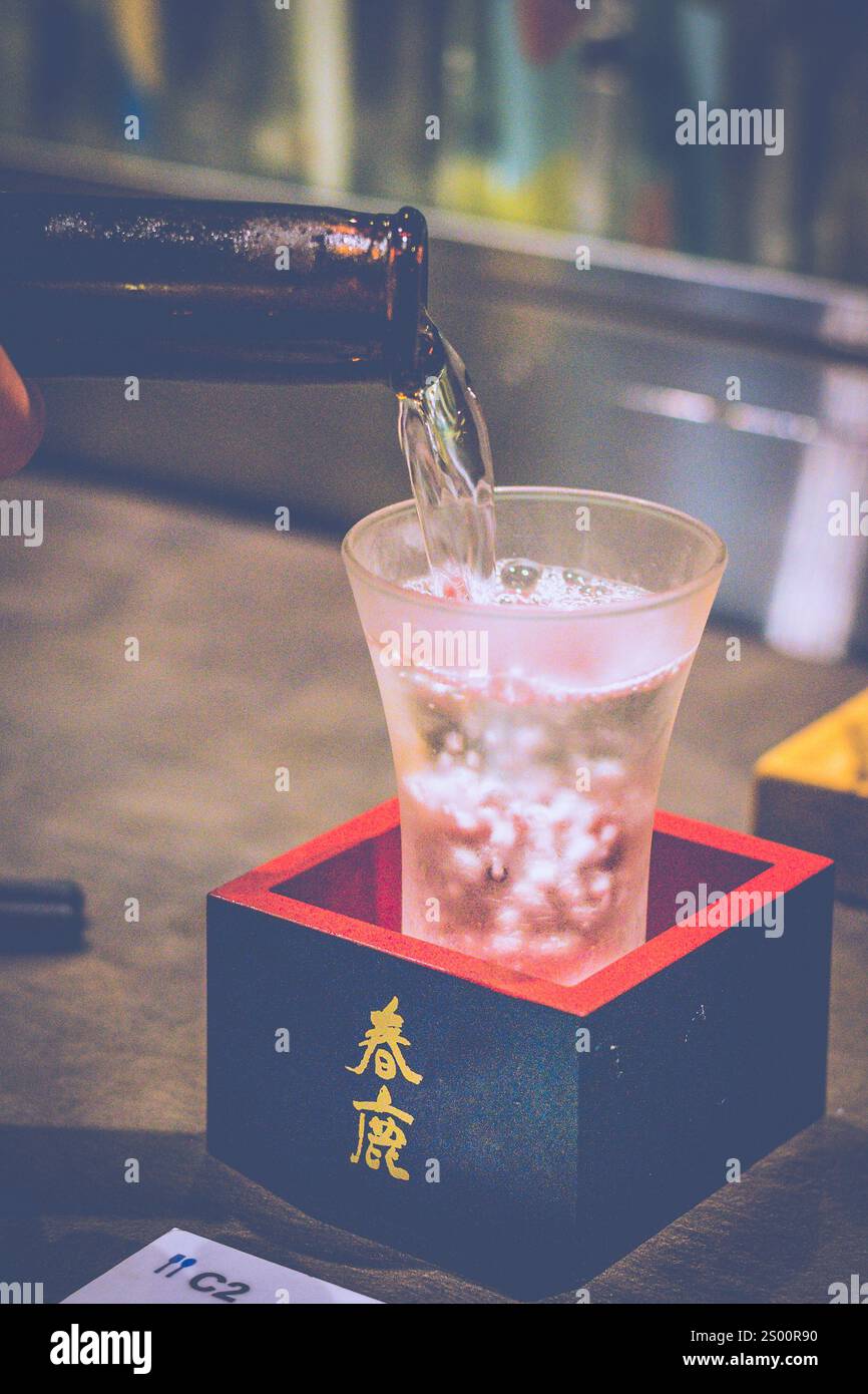 Japanese cold sake being poured into a sake glass in restaurant Stock ...