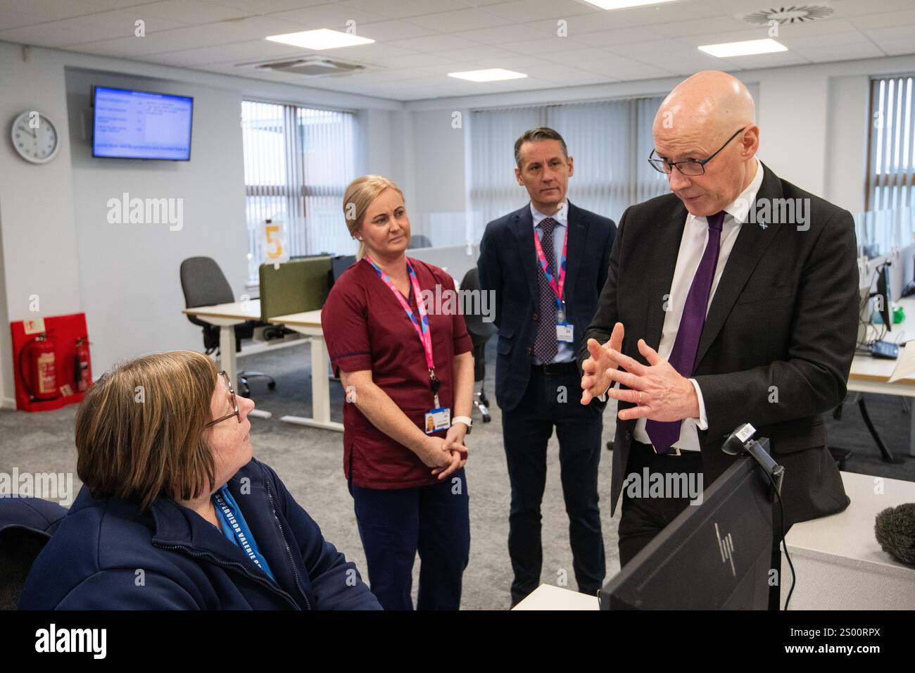 First Minister John Swinney with call handler Valerie Guilford as ...