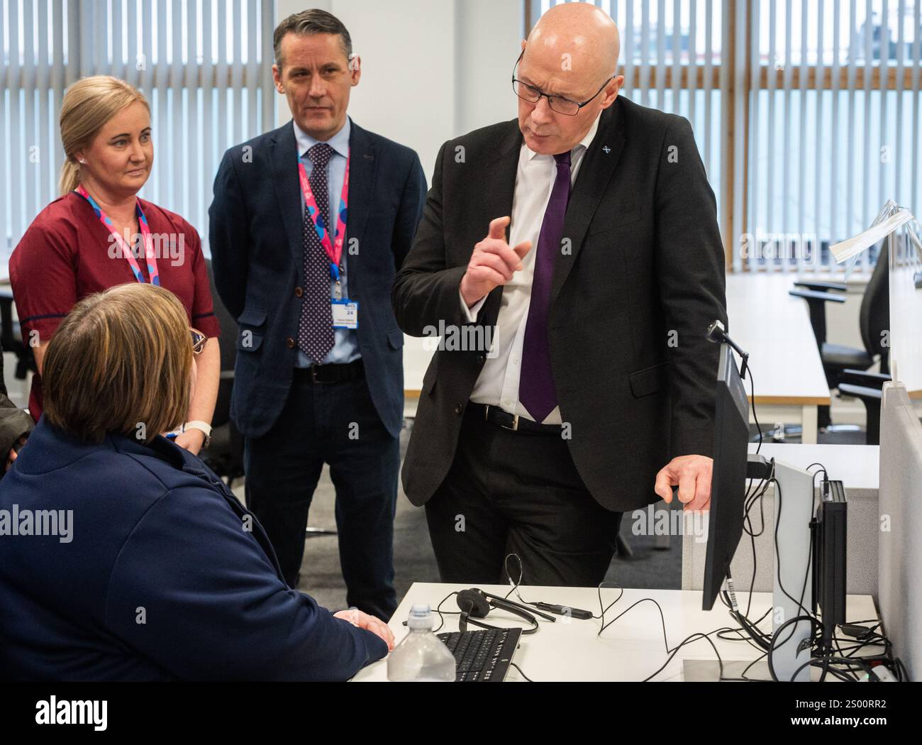 First Minister John Swinney with call handler Valerie Guilford as ...