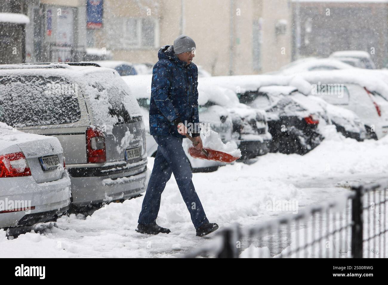 A man shovels snow from the street during heavy snowfall in Bihac ...