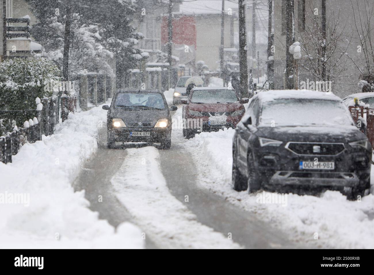 A car drives down the street during heavy snowfall in Bihac, Bosnia ...