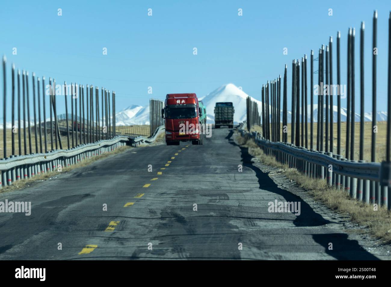(241223) -- LHASA, Dec. 23, 2024 (Xinhua) -- Trucks pass through a road ...