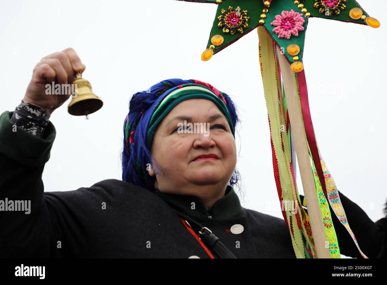KYIV, UKRAINE - DECEMBER 22, 2024 - A woman rings a bell as members of ...