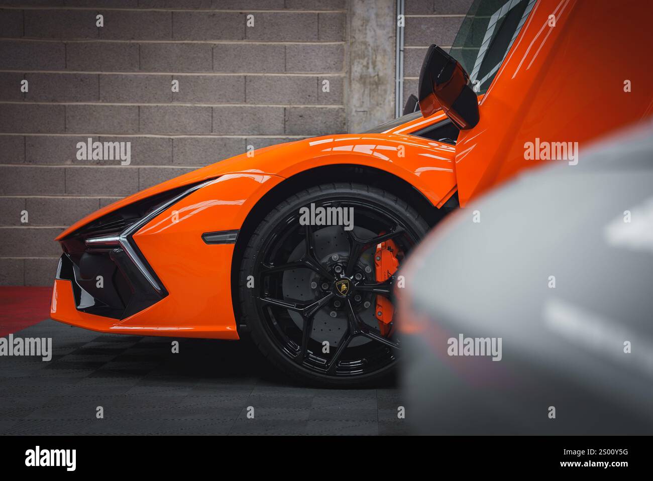 The image captures a close up of an orange Lamborghini Revuelto ...
