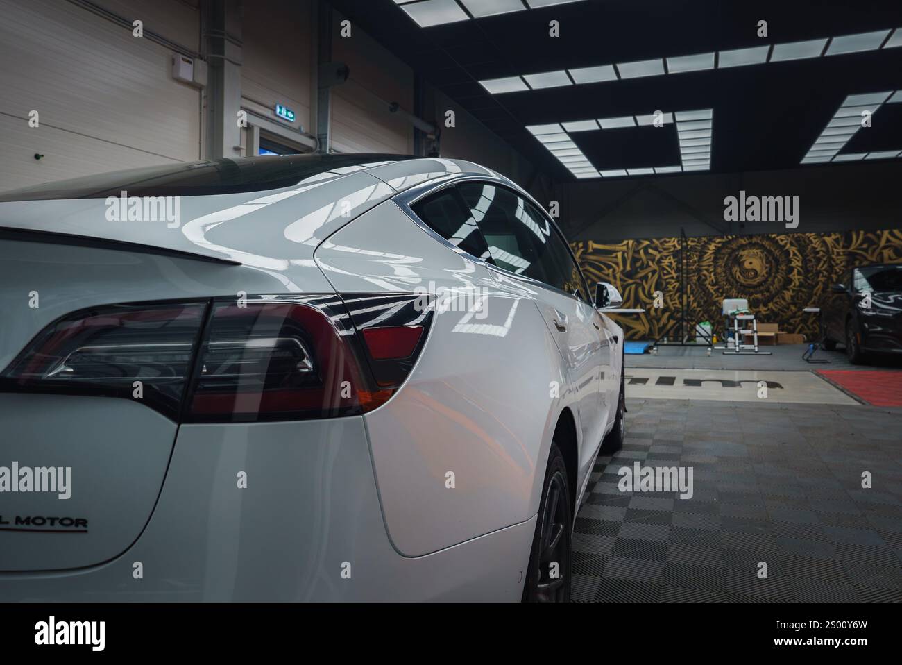 White Tesla Model 3 in Indoor Showroom with Patterned Wall Mural Stock ...