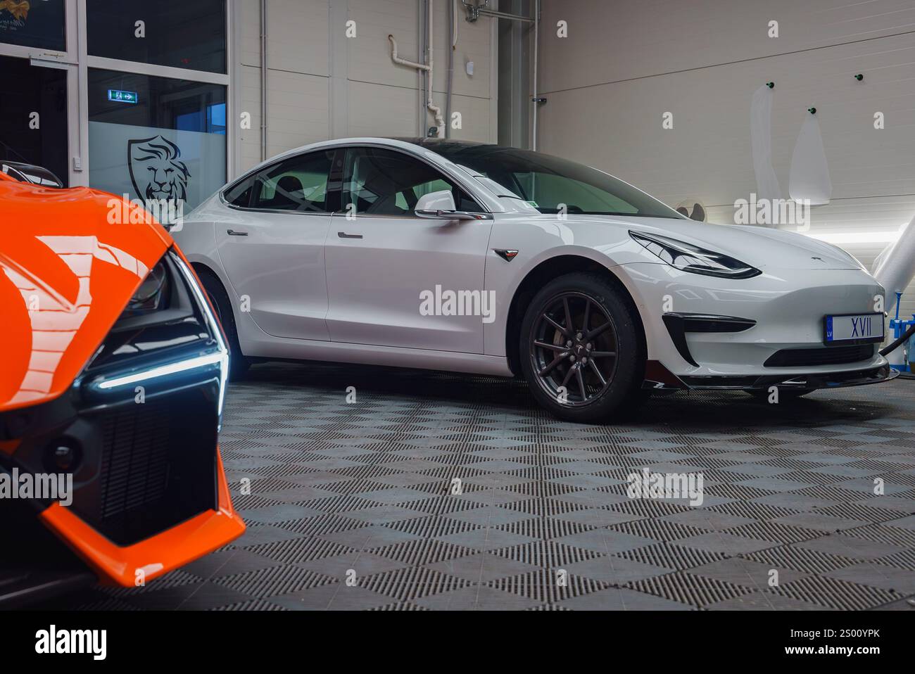 Tesla Model 3 and Lamborghini Revuelto in Modern Showroom Setting Stock ...