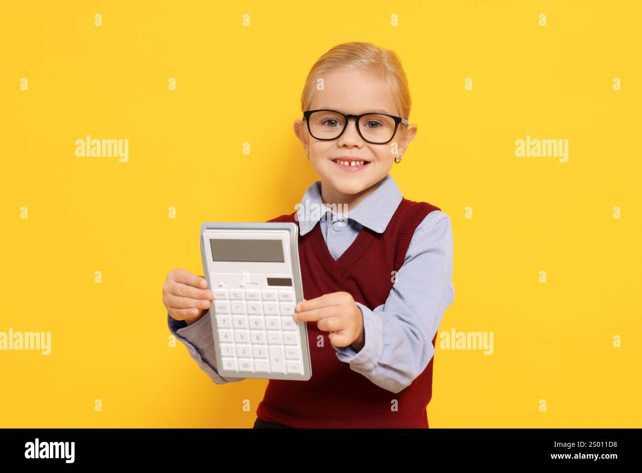 Little girl with calculator pretending to be accountant on orange ...