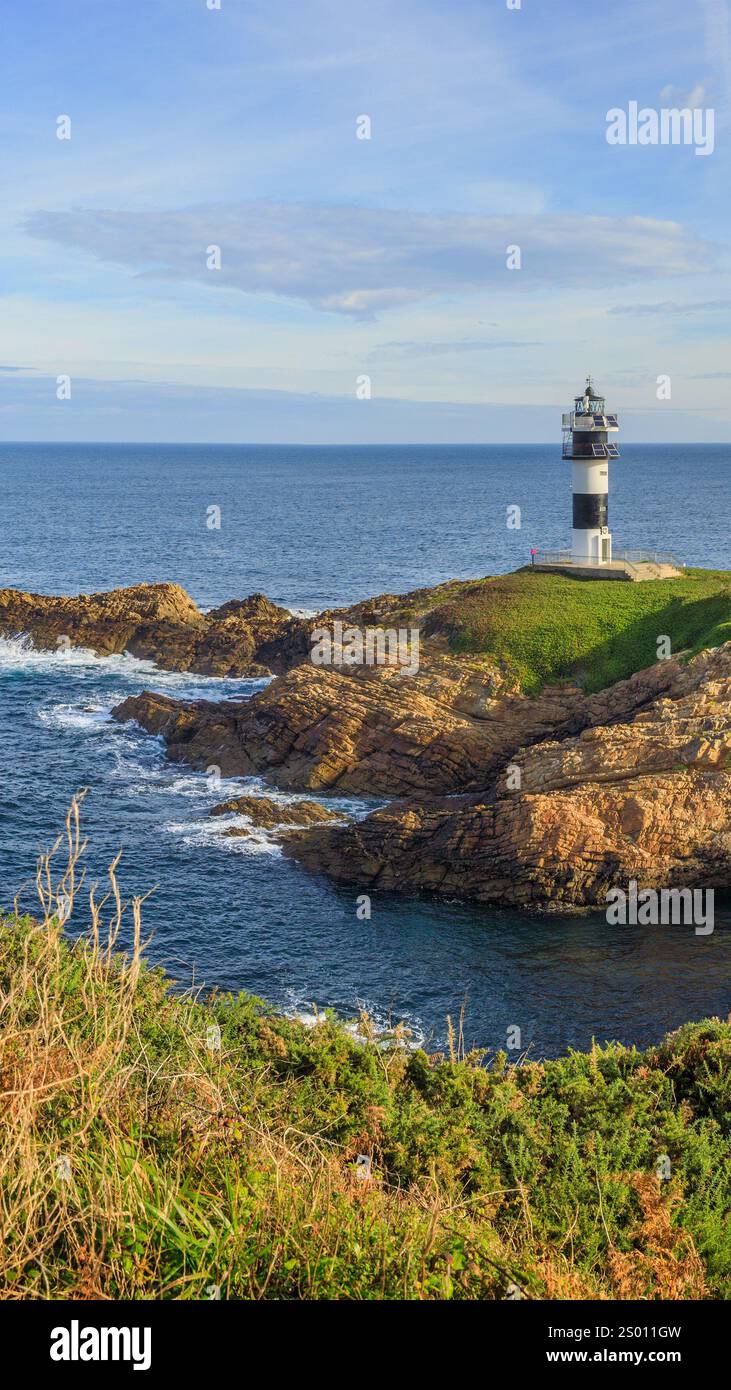 The Ribadero Lighthouse in northern Spain stands on a rocky promontory ...