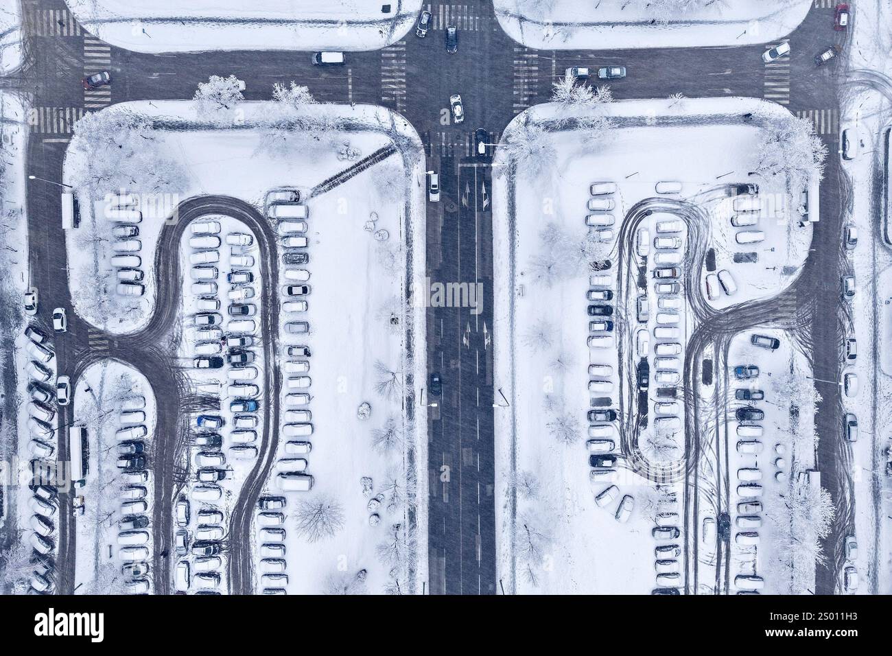 An aerial view of traffic and parked cars during heavy snowfall in ...