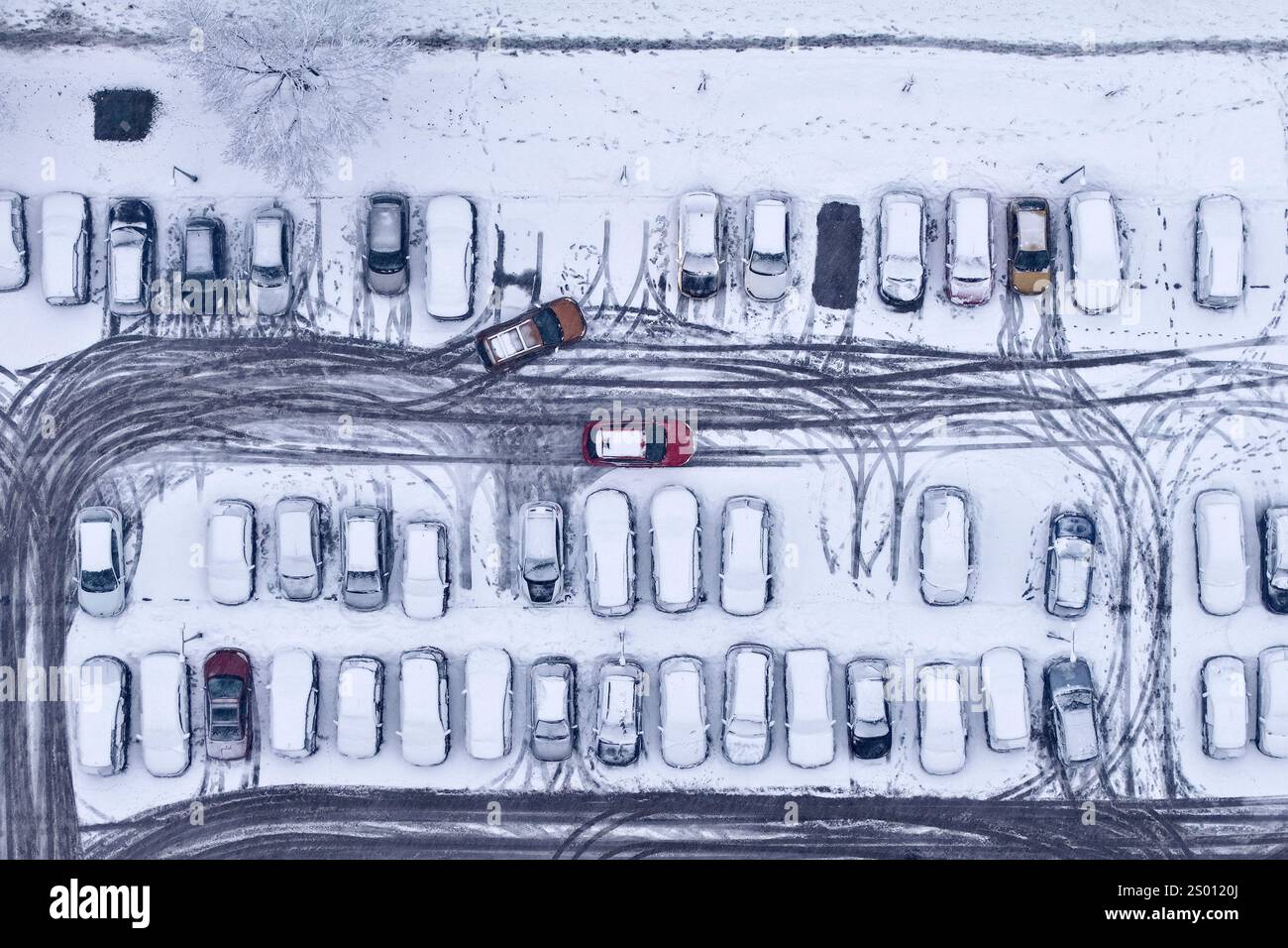 An aerial view of traffic and parked cars during heavy snowfall in ...