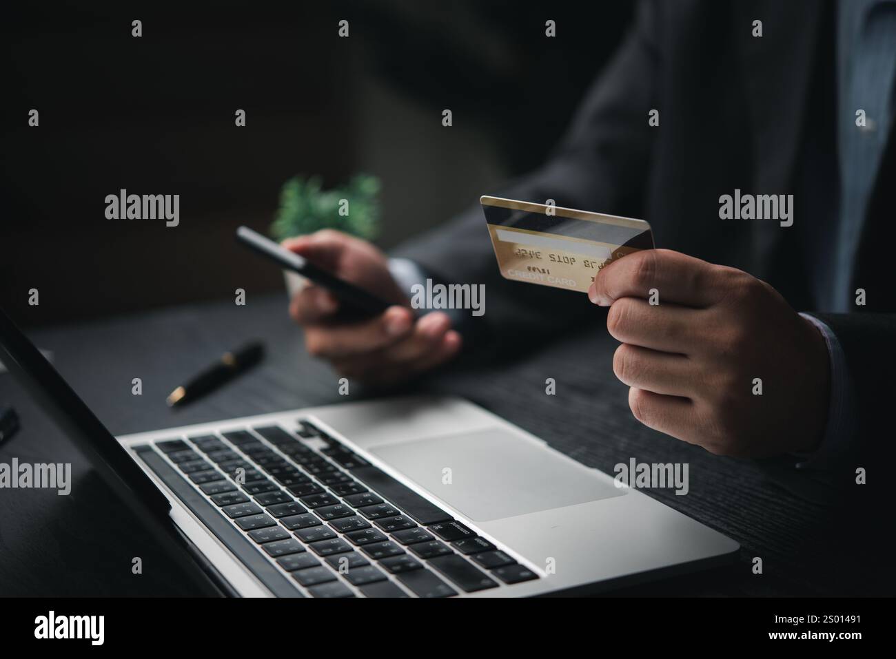 Business professional using a smartphone and credit card for a secure online transaction on a ...