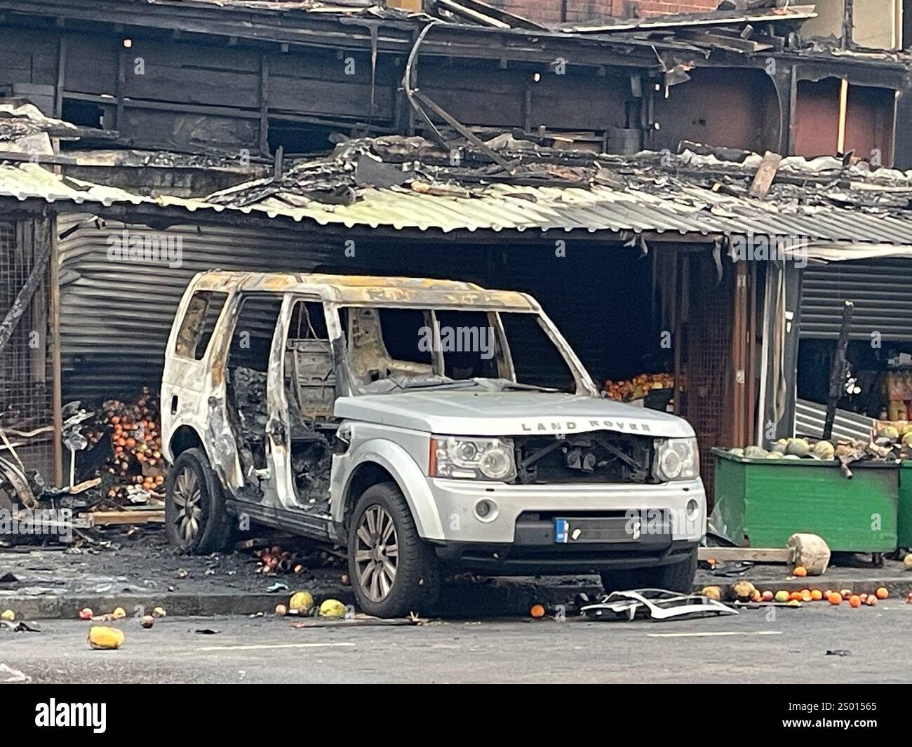 The remains of a burnt out car at the scene of a fire at a mixed ...