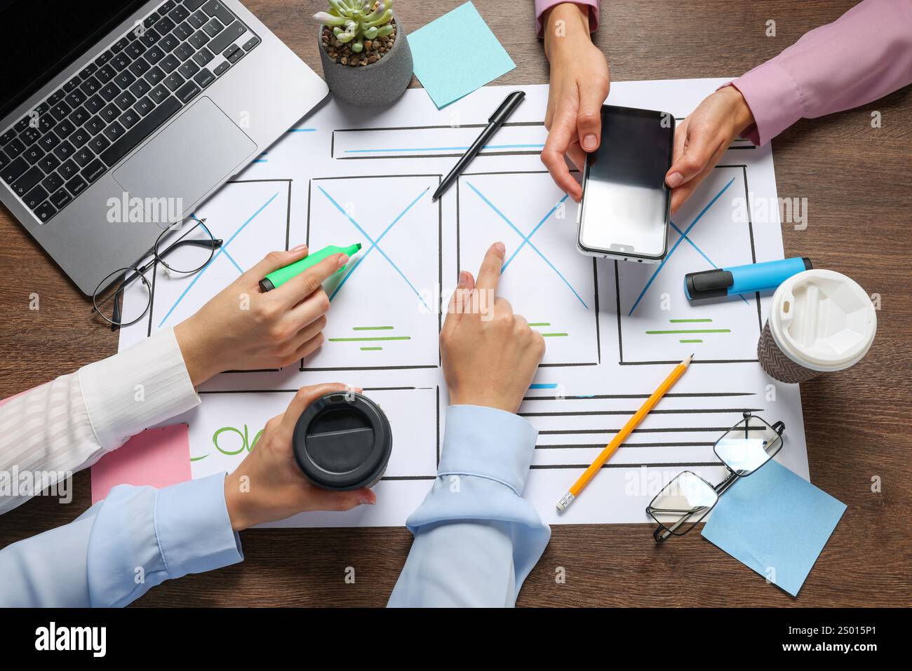 Developing UI design. Designers creating website wireframe on paper at ...