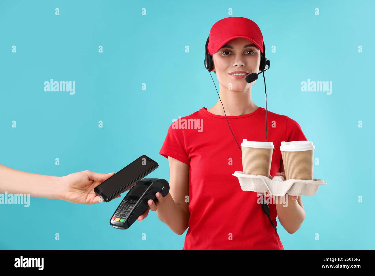 Fast-food worker taking payment from client via terminal on light blue ...
