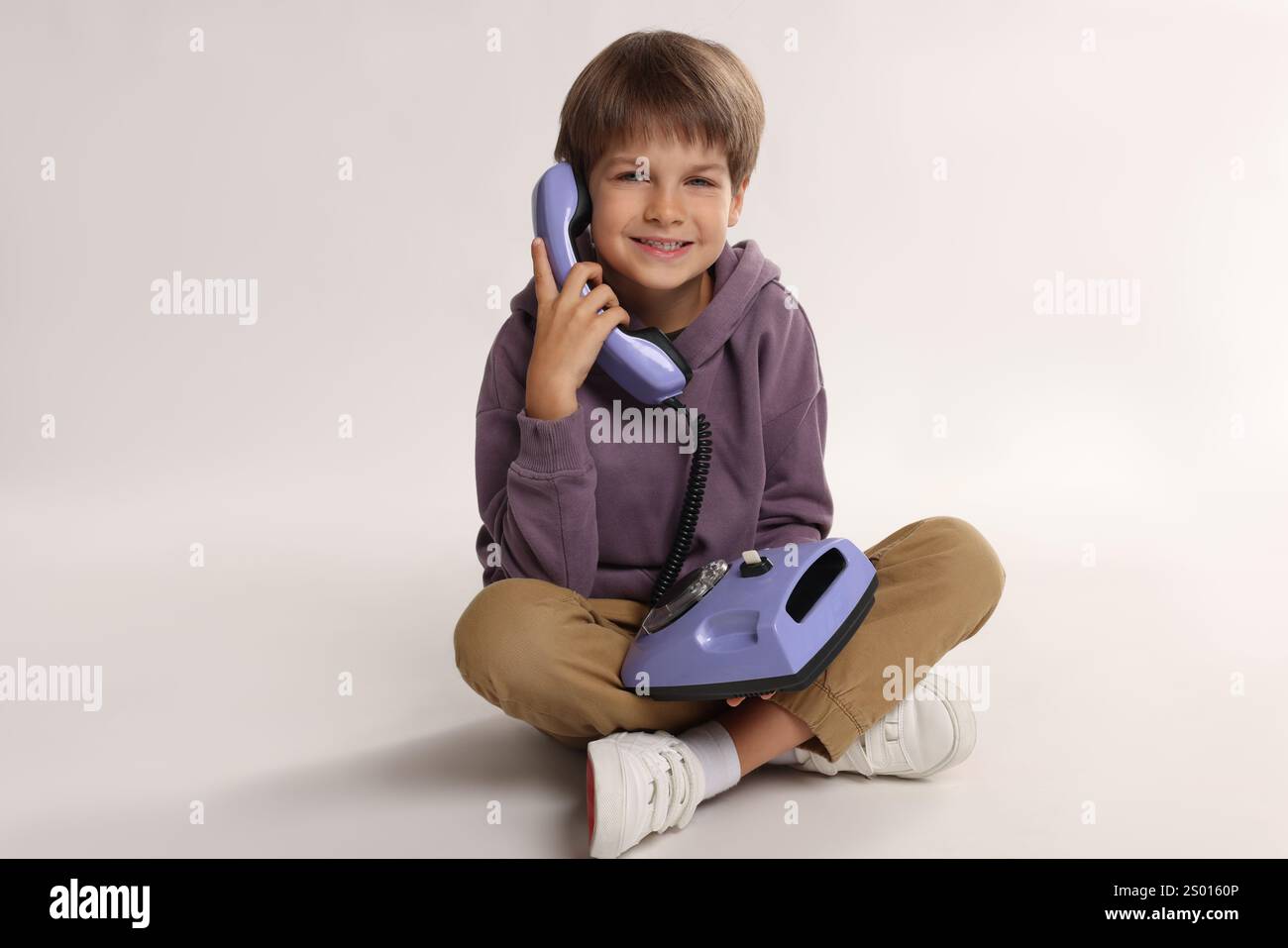 Cute little boy with old telephone on white background Stock Photo - Alamy