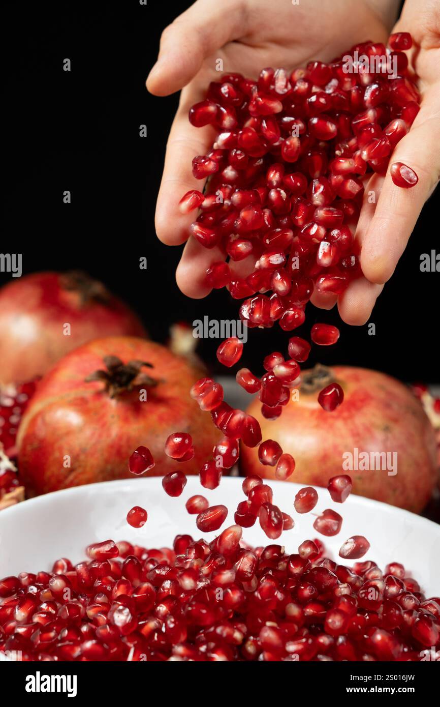 A handful of pomegranate seeds, seeds pouring out of hands Stock Photo ...