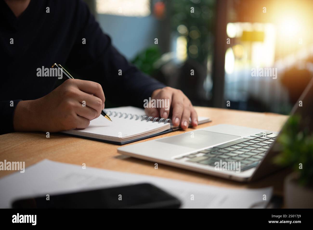 Person taking notes with pen on notebook, symbolizing planning ...