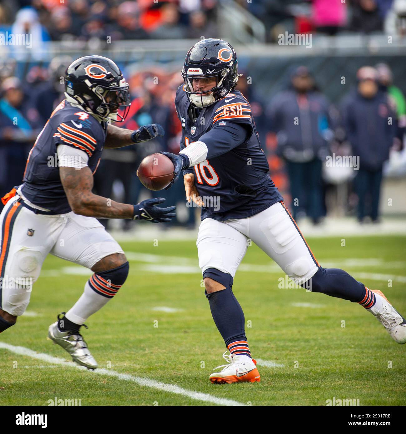 Chicago Bears quarterback Caleb Williams (18) hands the ball off to D ...