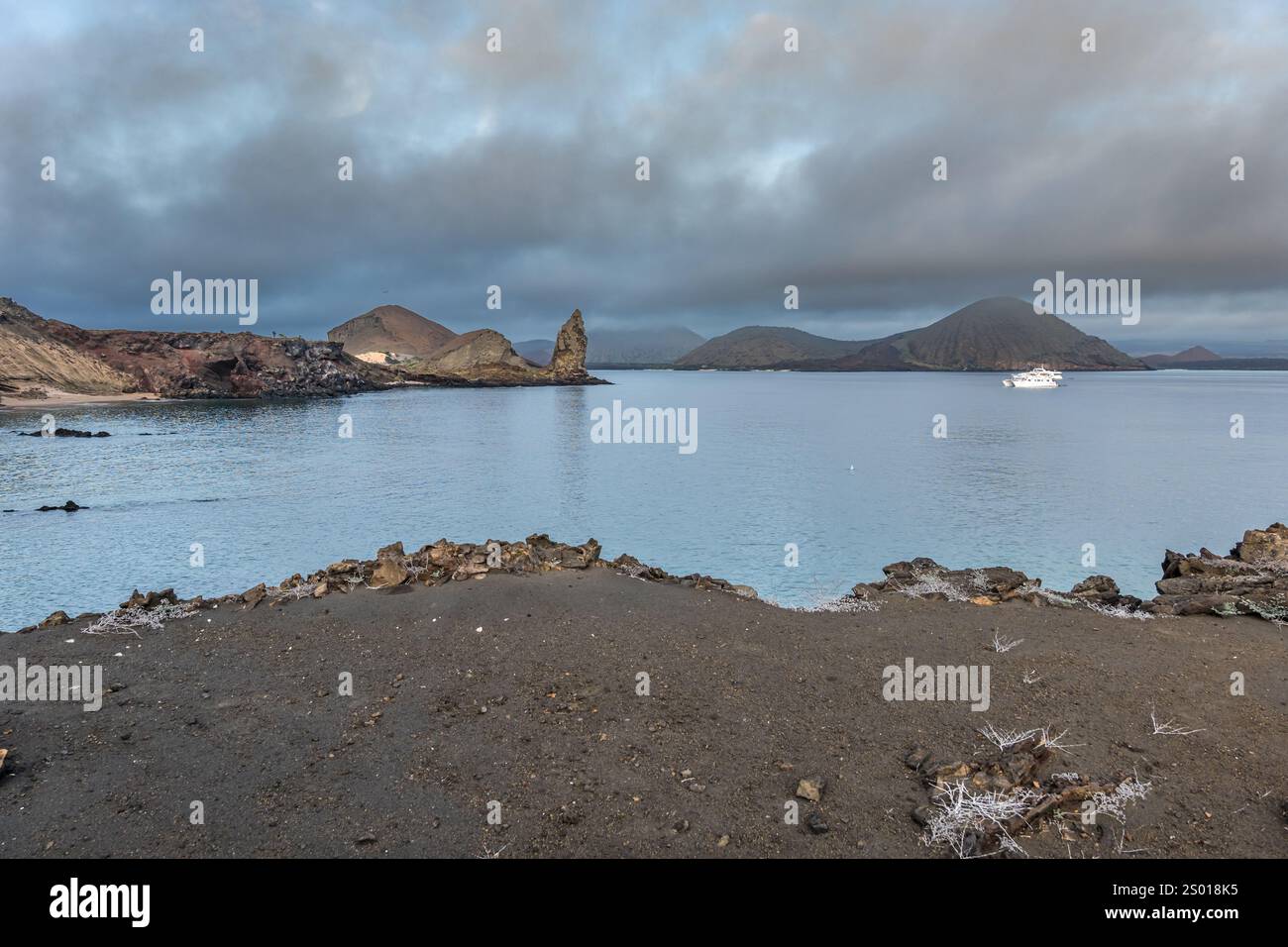 View across bay to sea stack volcanic rock formation with cruises ships ...