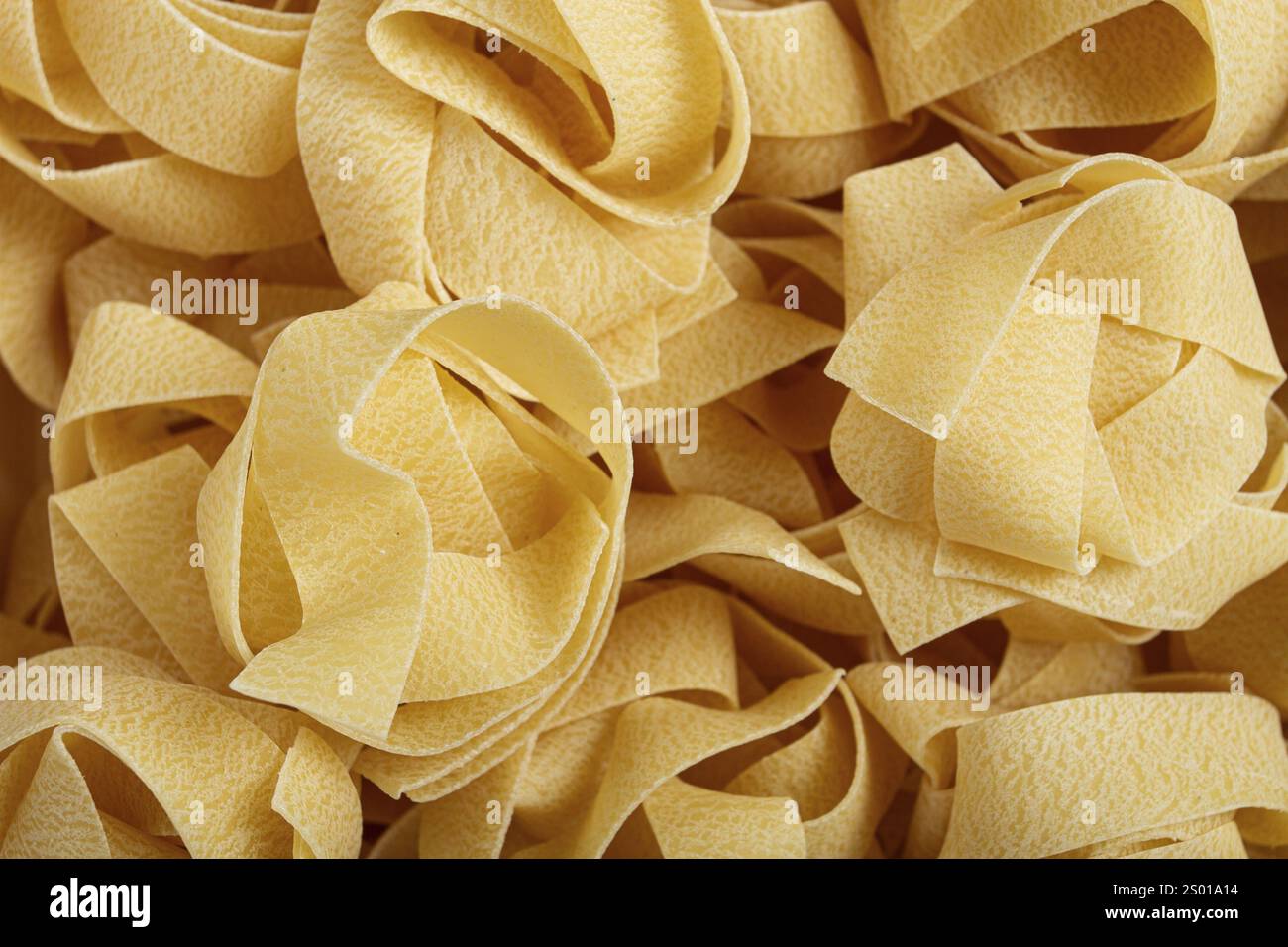 Raw pappardelle pasta, pasta nests, in a paper box, top view, no people ...