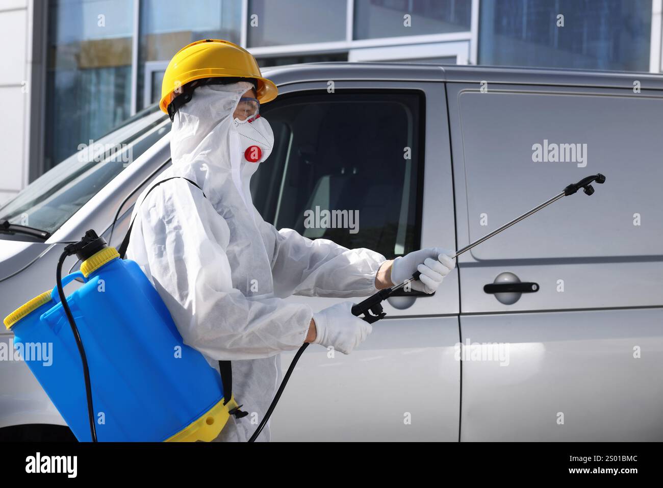 Pest control worker with spray tank near gray minibus outdoors Stock ...