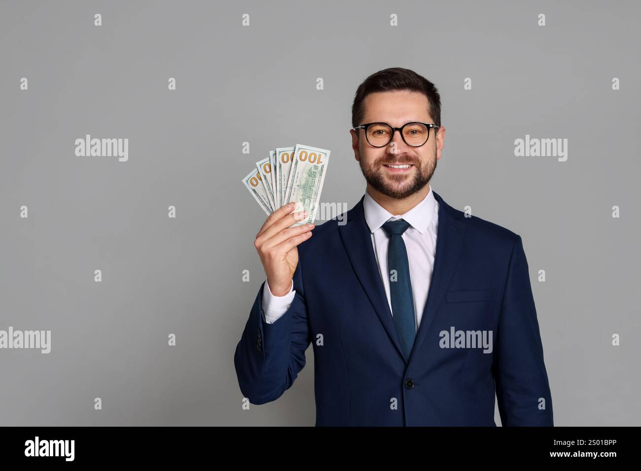Portrait of banker with dollar banknotes on grey background, space for ...