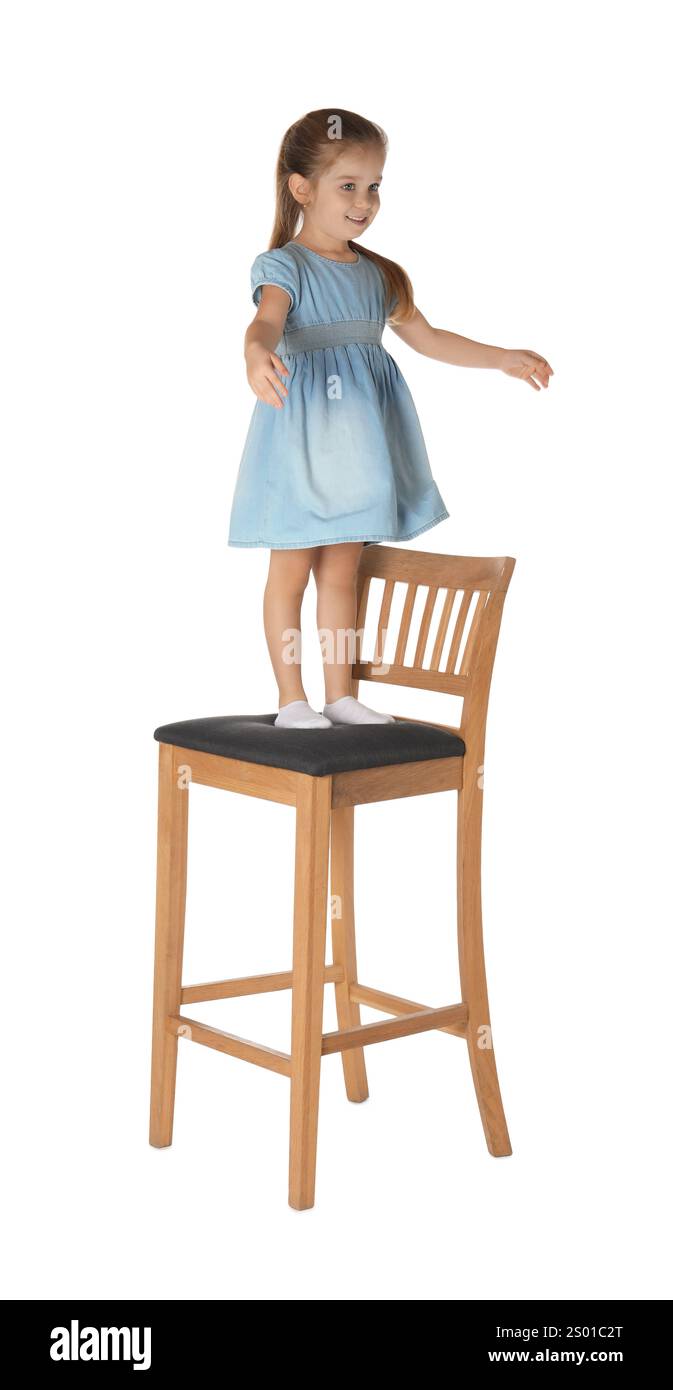 Little girl standing on stool against white background Stock Photo - Alamy