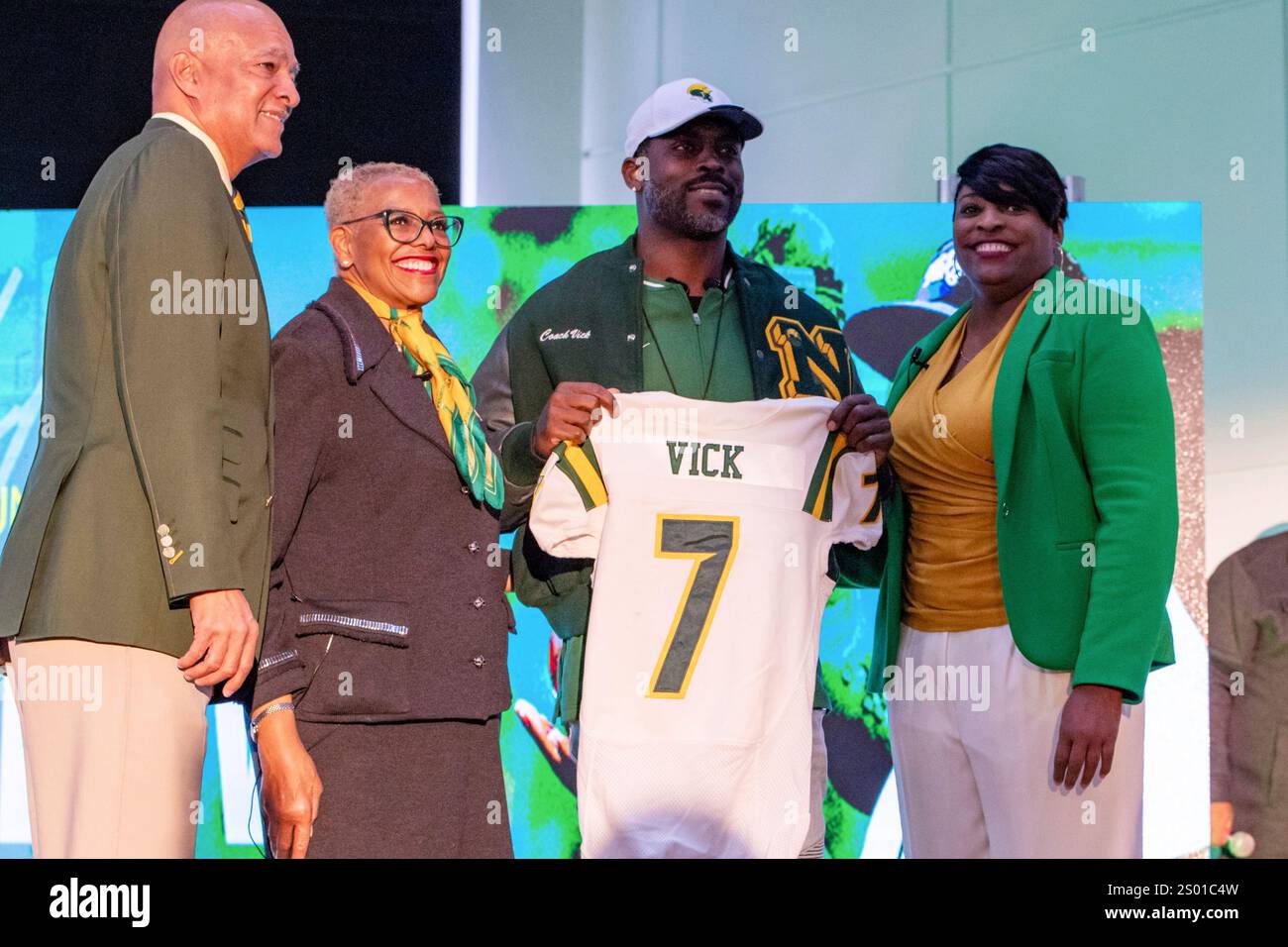 Michael Vick holds up a number seven Norfolk State jersey with his name ...