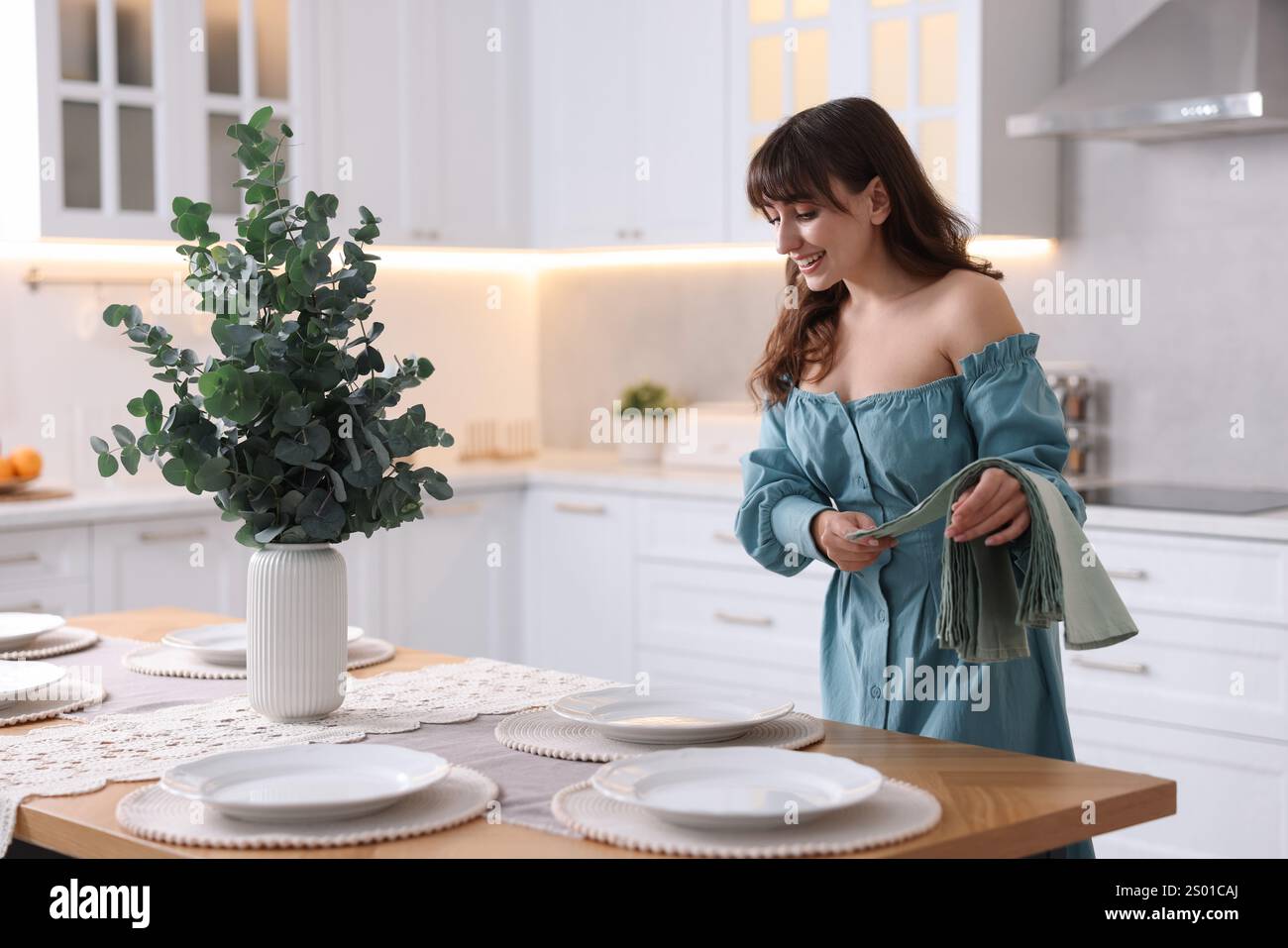Woman setting table for dinner at home Stock Photo - Alamy