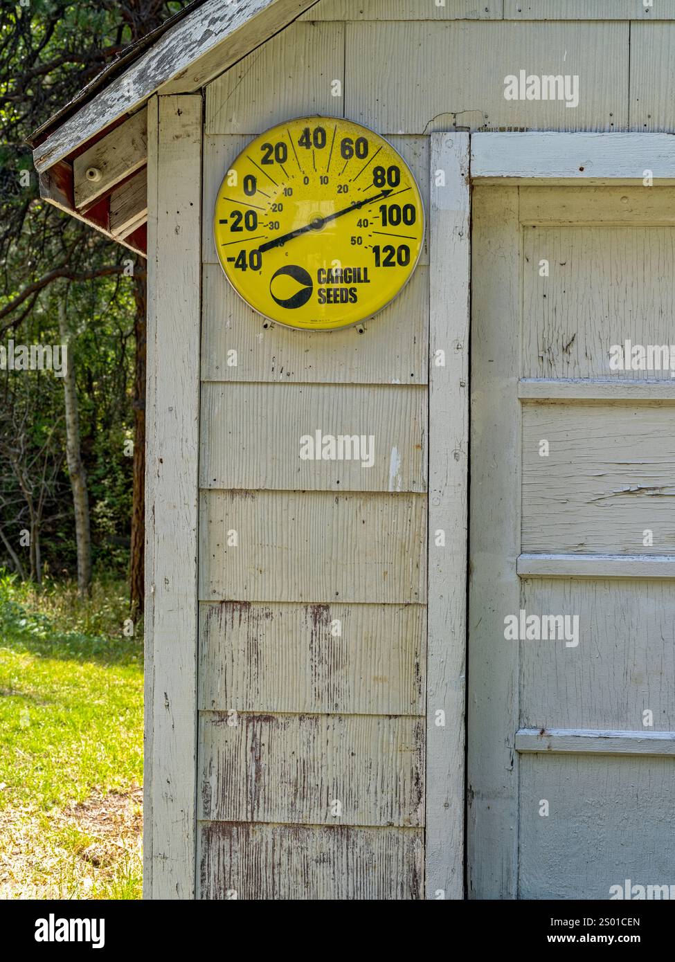 A Cargill Seeds branded thermometer hanging on the exterior of a garage ...