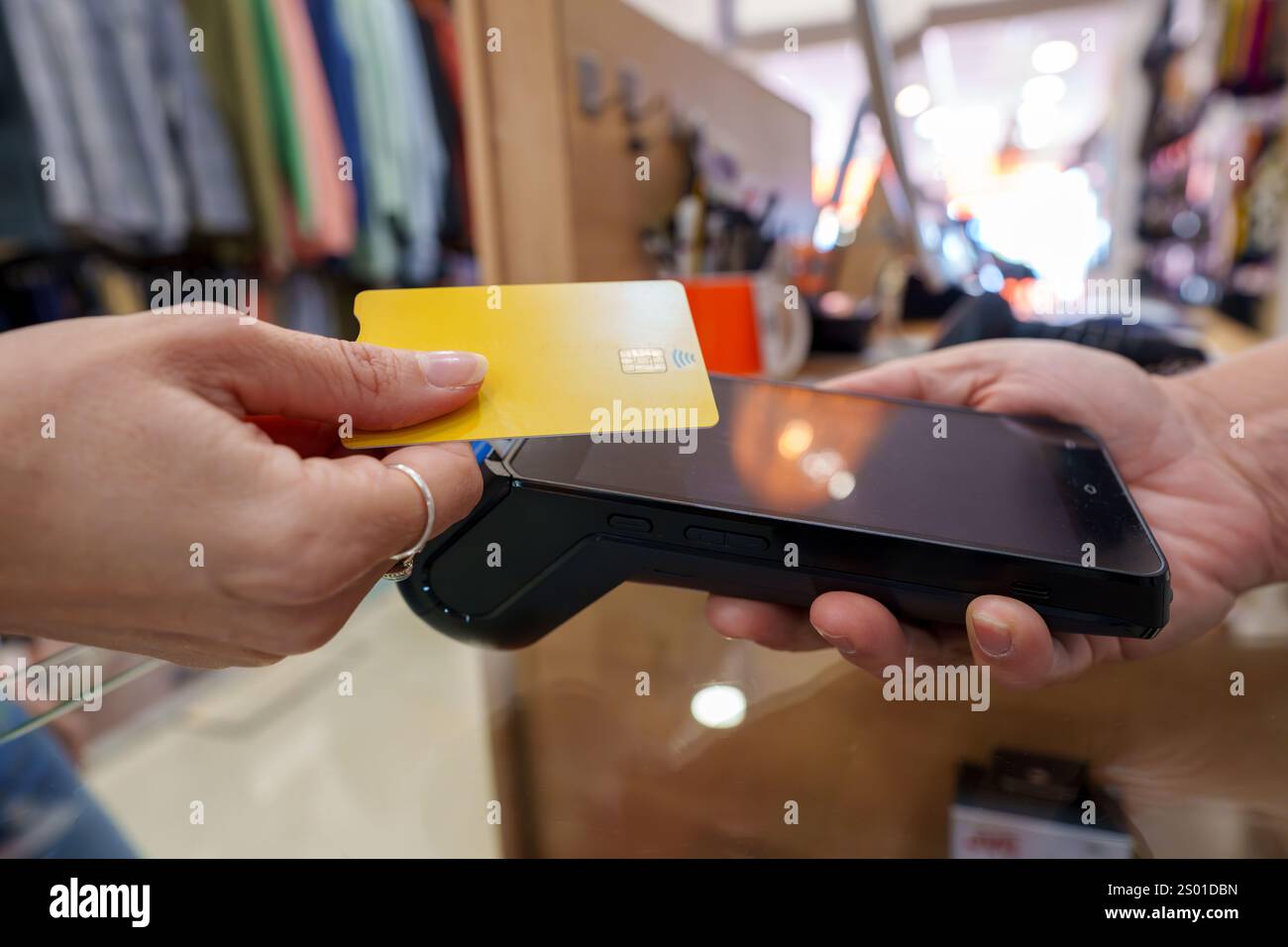 Woman paying with contactless credit card, completing retail purchase ...