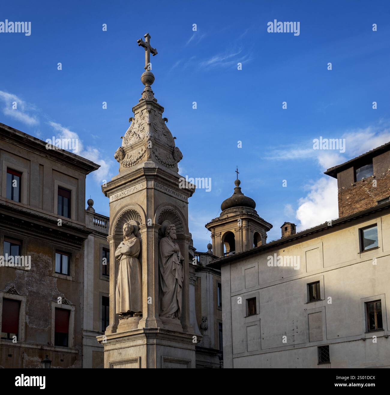 A historic monument featuring two statues, a cross on top, set against ...