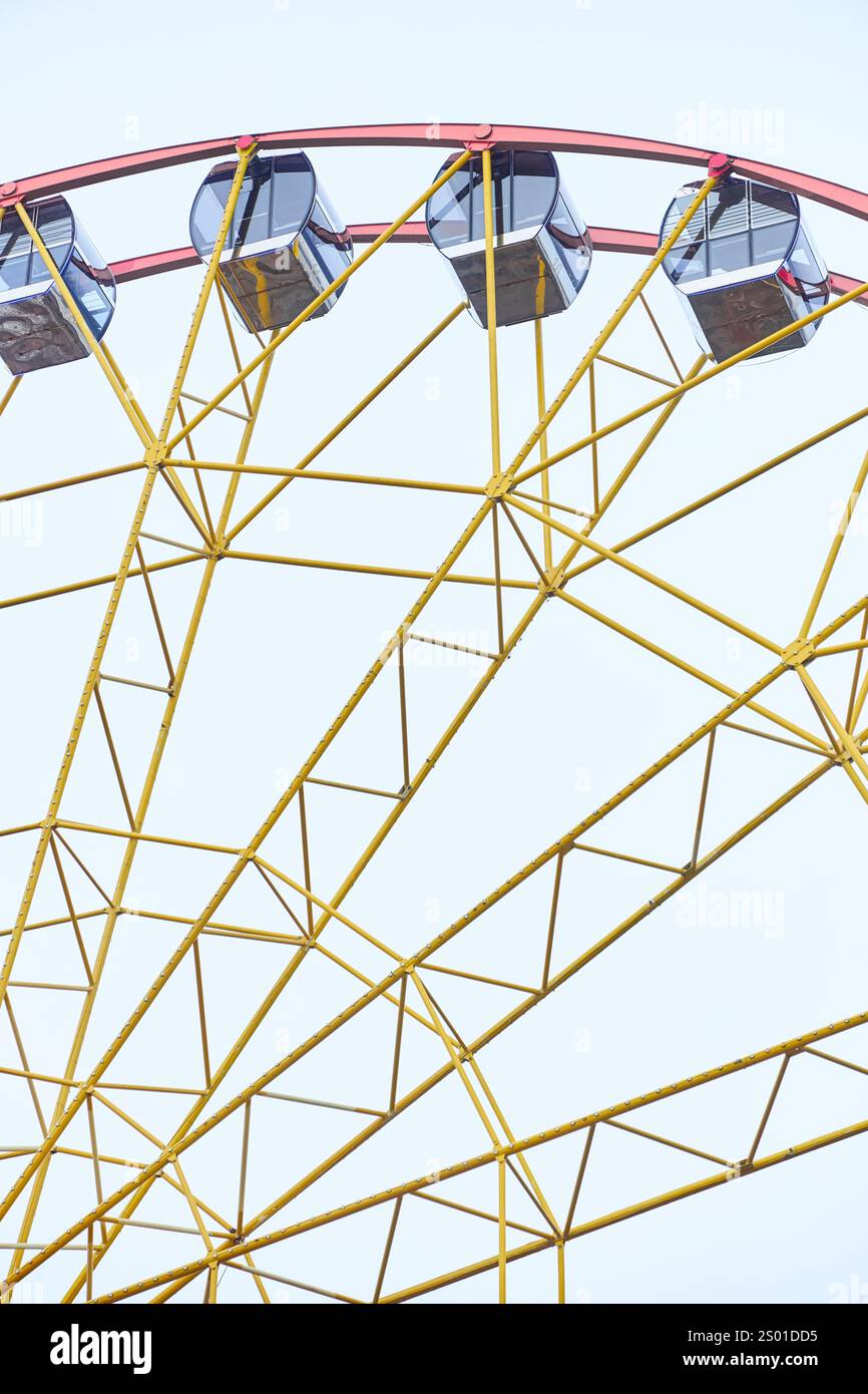 Yellow ferris wheel with modern cabins in the Panfilov amusement park ...