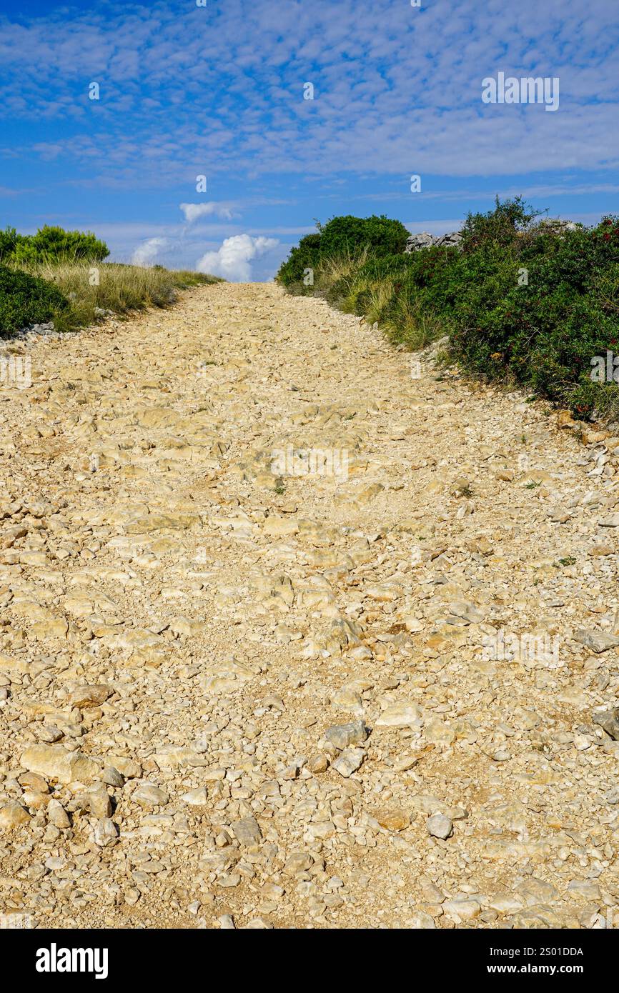 Abstract coarse rocky gravel road in rural area, perspective view, blue ...