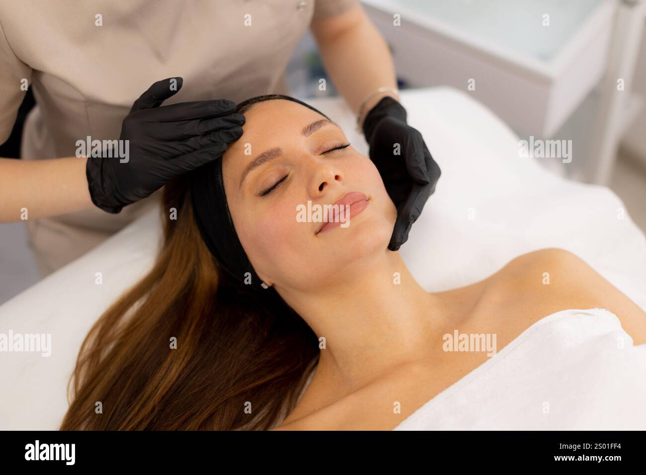 A skilled professional performs a soothing facial on a relaxed client ...
