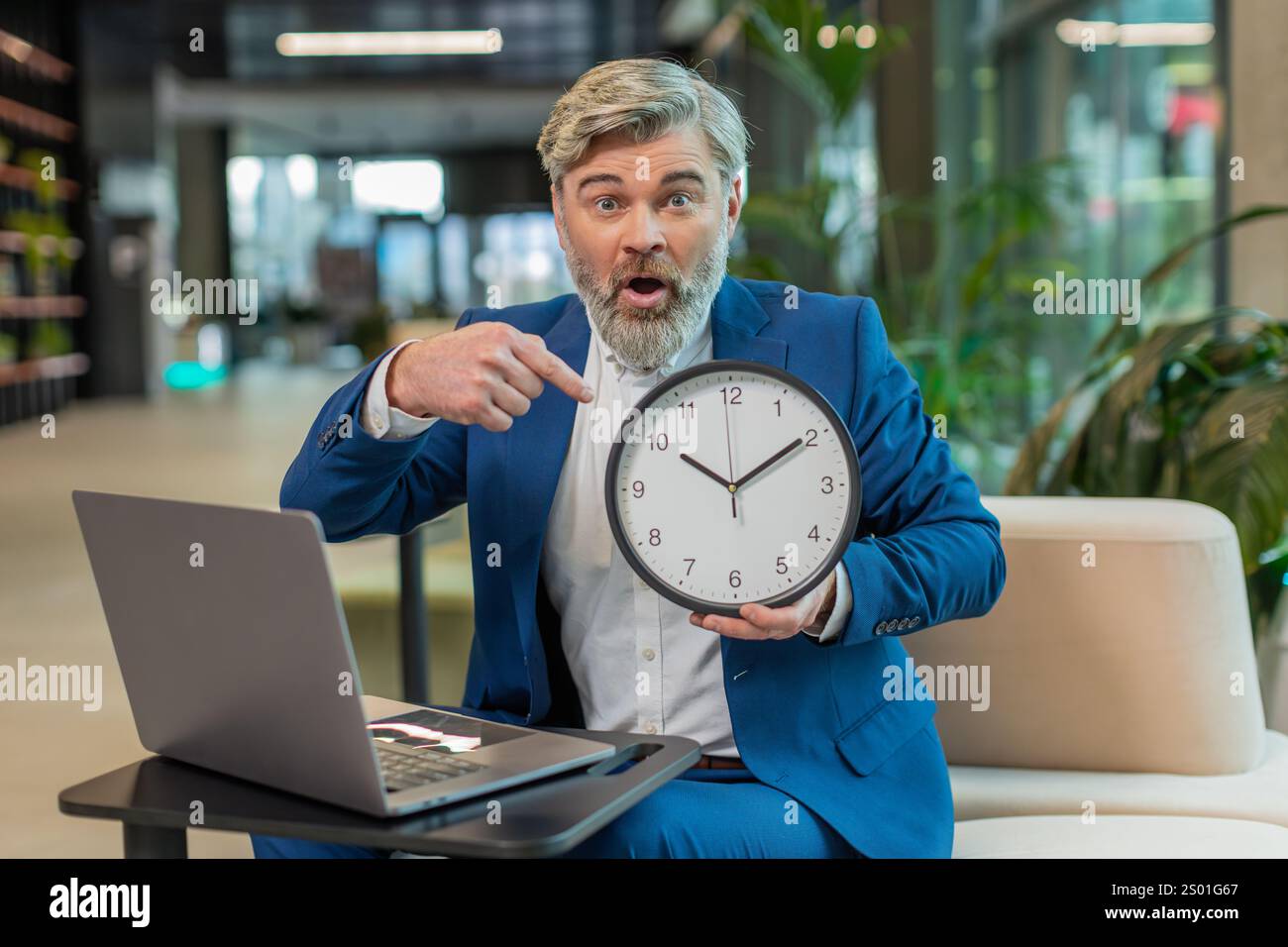 It is your time. Mature boss businessman with laptop showing time on ...