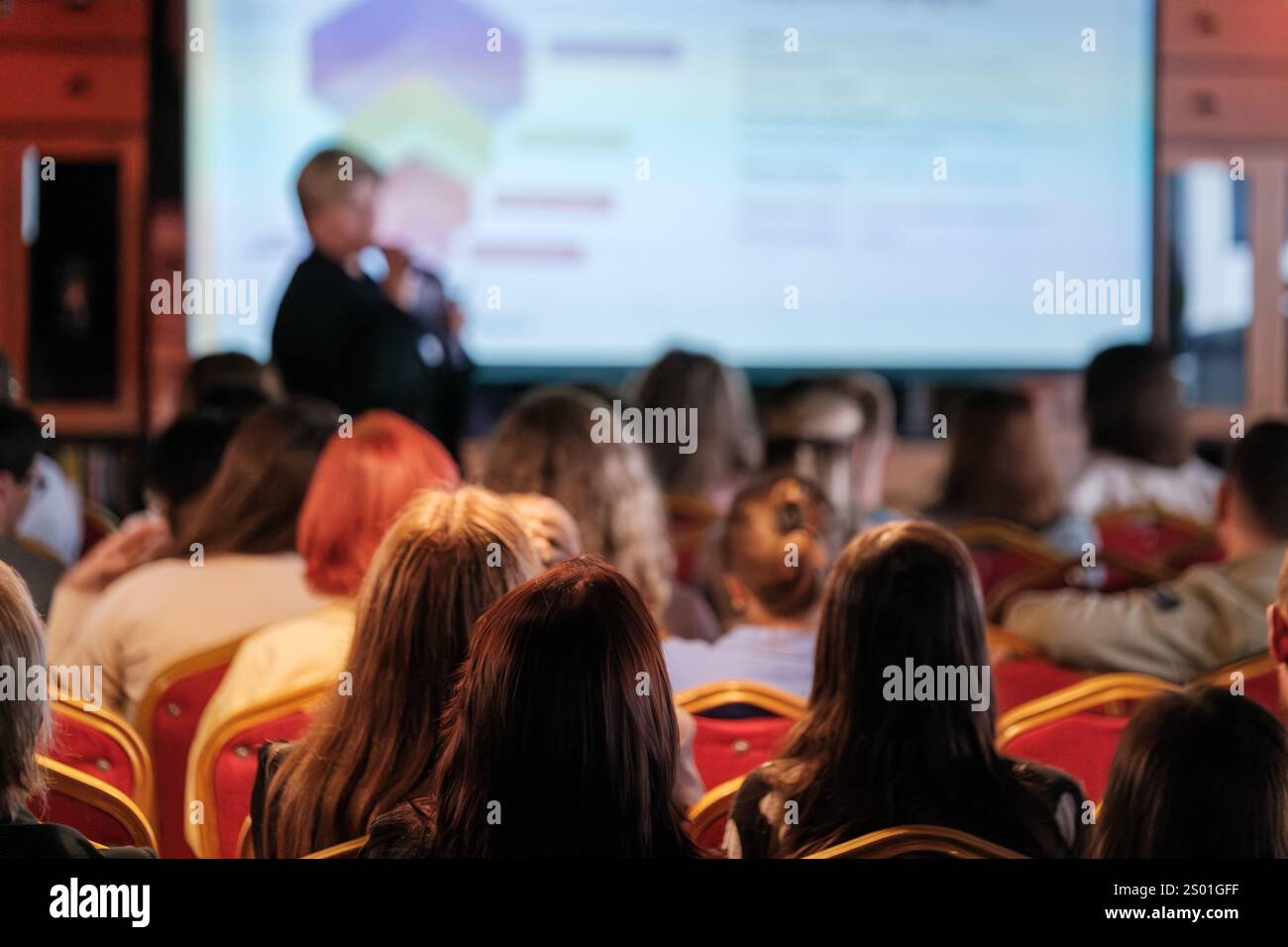 Group of people attending presentation, focusing on speaker and ...