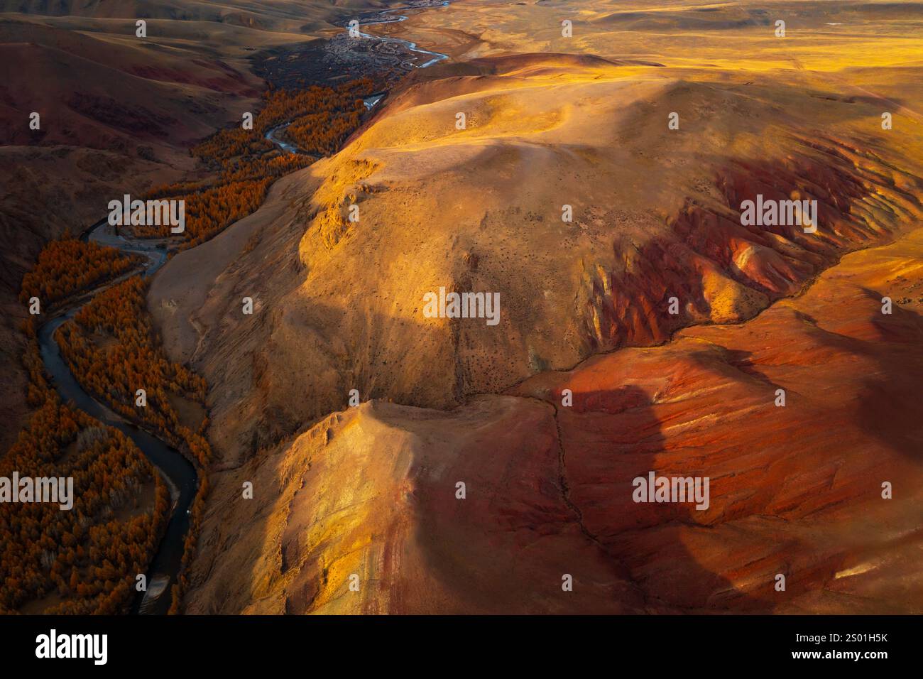 Vivid red and orange-hued mountains with a winding river captured from ...