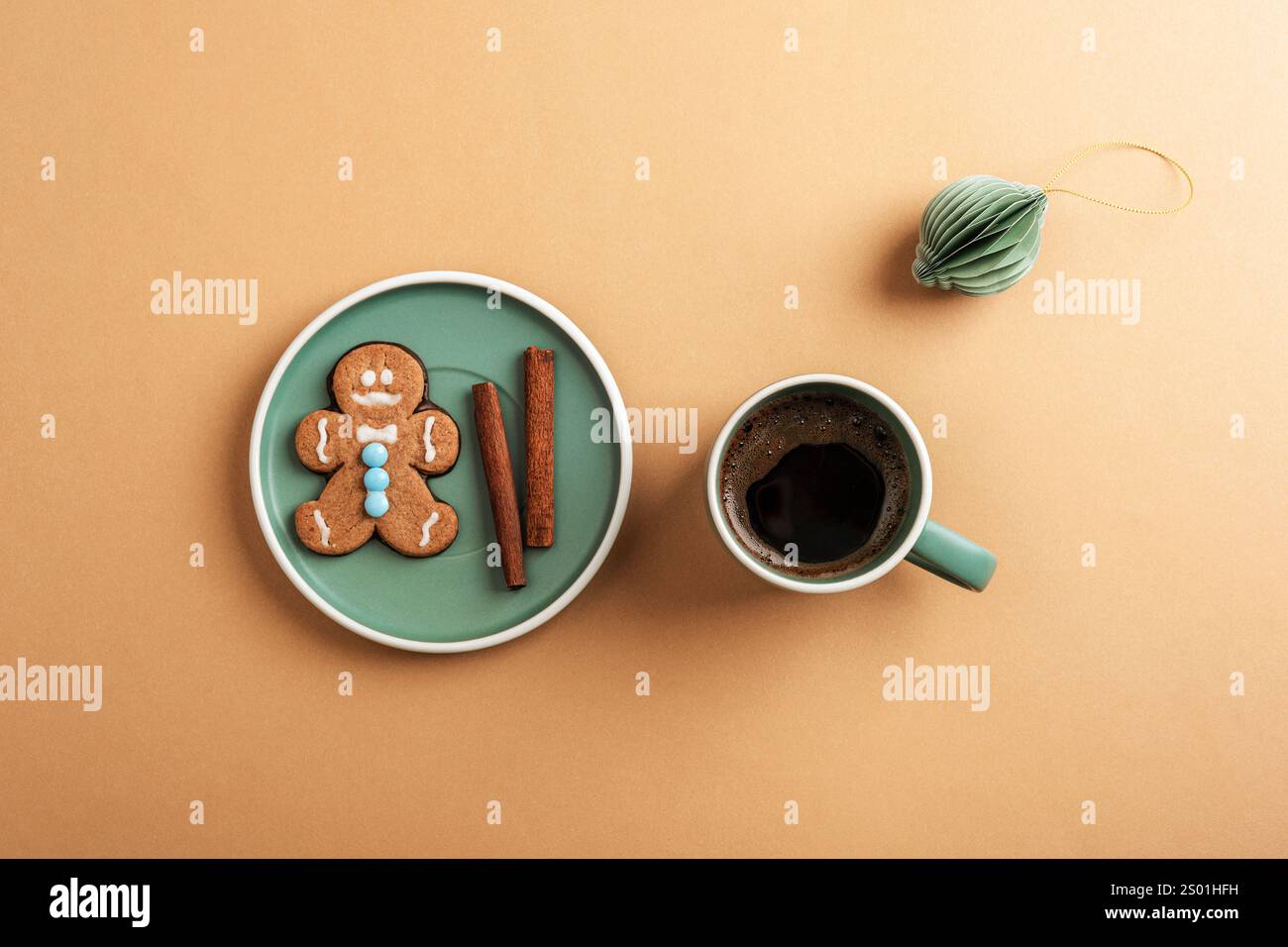 Flat lay of a gingerbread cookie with cinnamon sticks and coffee on a ...