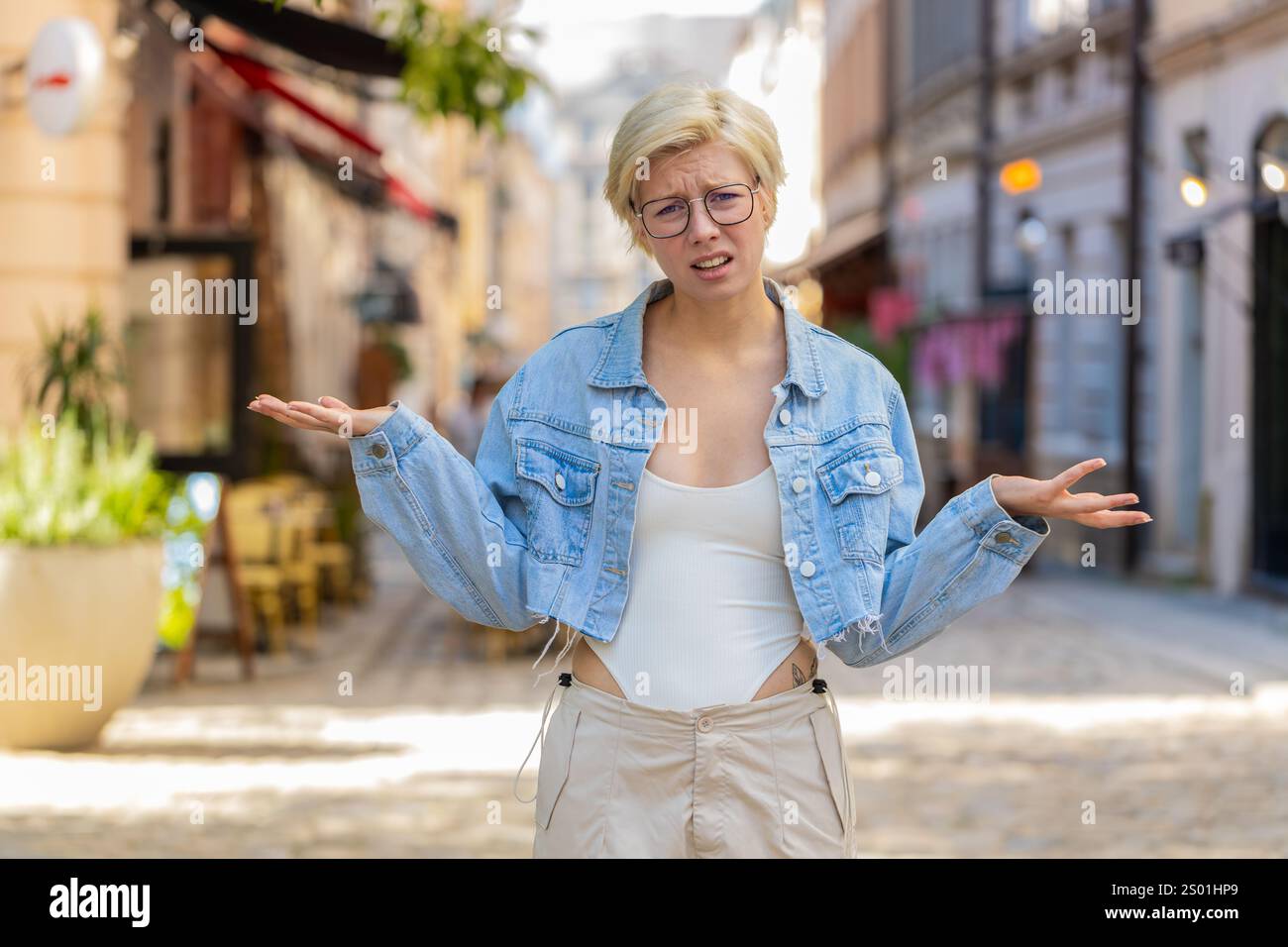 Doubtful sad frustrated young blonde woman shrugging shoulders dont ...