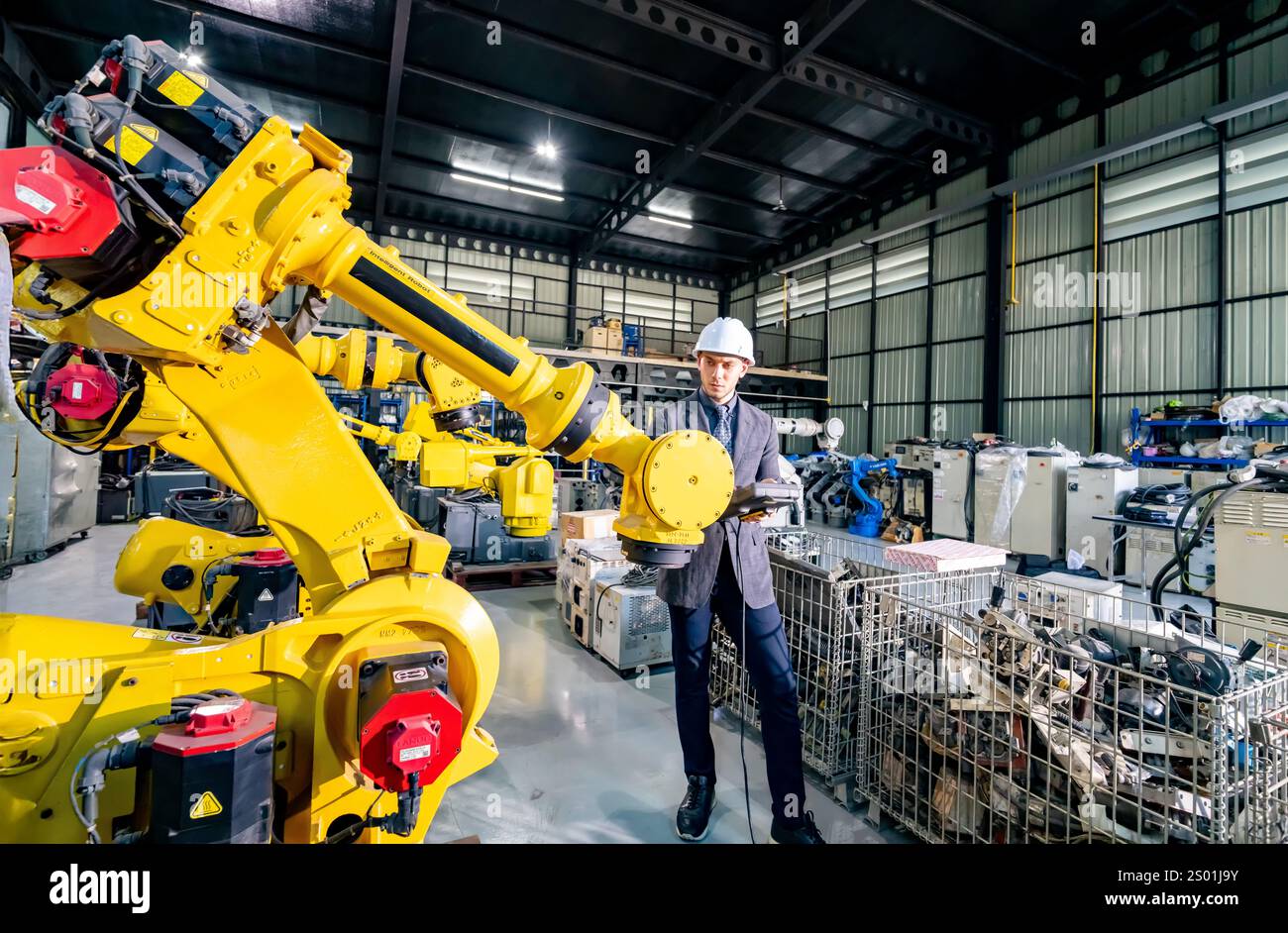 A robotics expert stands confidently among advanced robotic arms in a ...