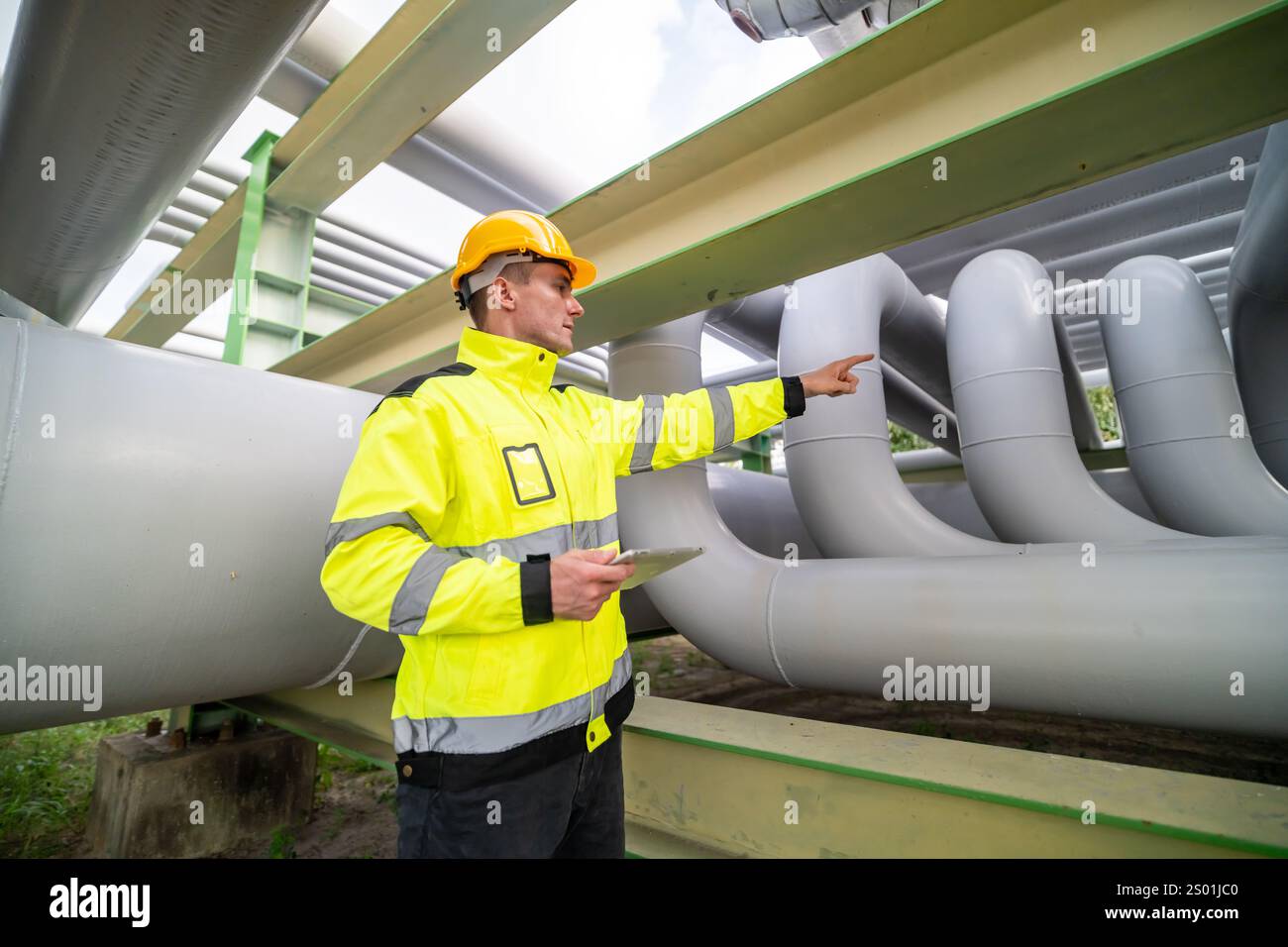 A safety-conscious worker in a high-visibility jacket and hard hat ...