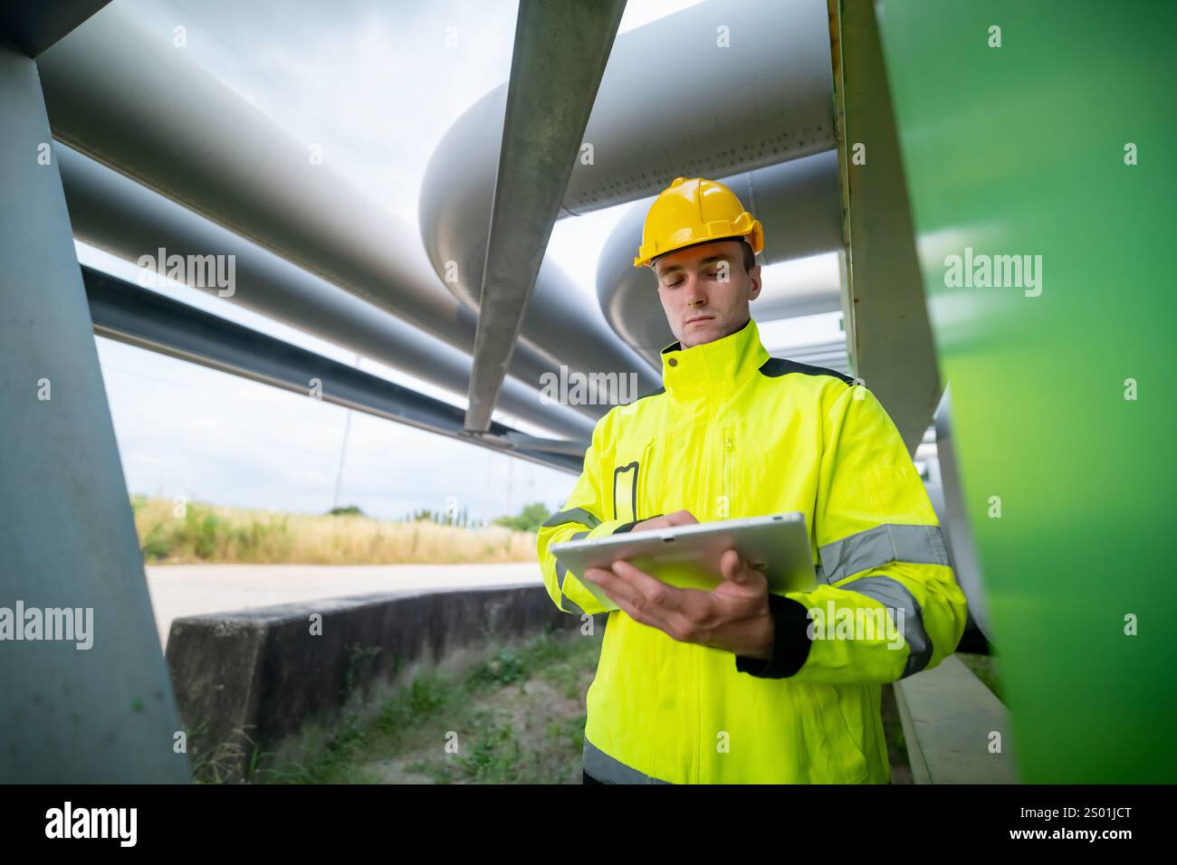 A construction worker wearing a bright yellow safety jacket and helmet ...