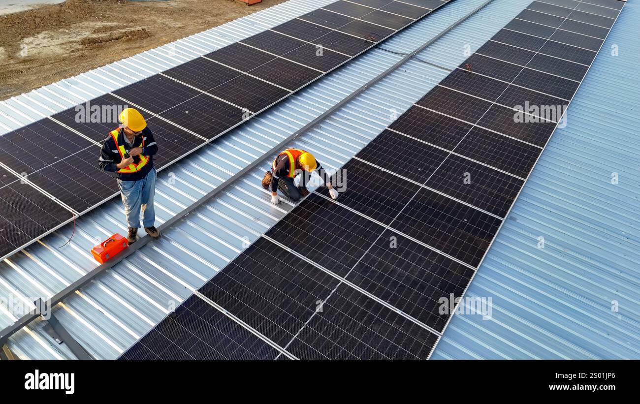 Workers are engaged in the installation of solar panels on a metal ...