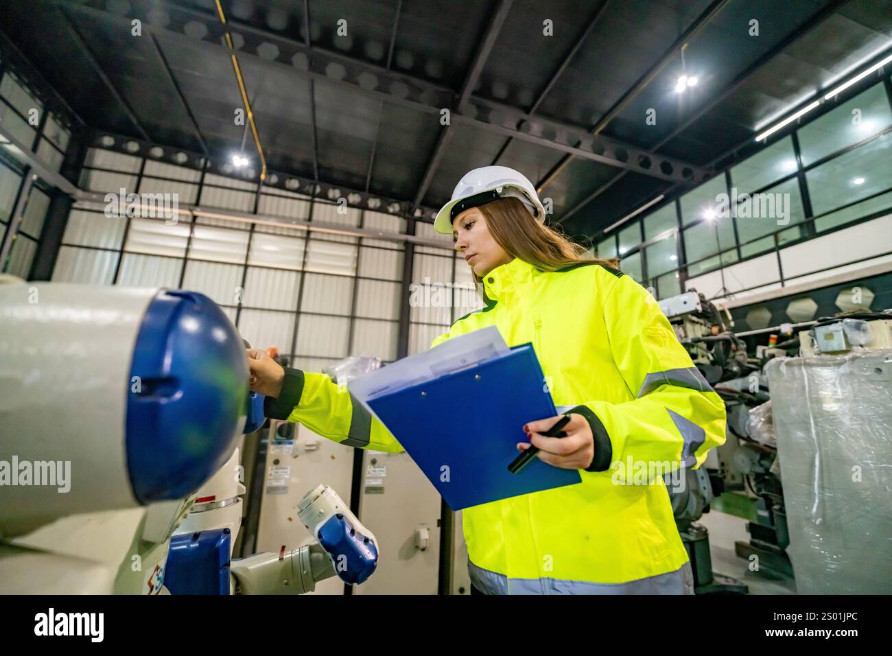 A professional checks machinery controls in an industrial setting while ...