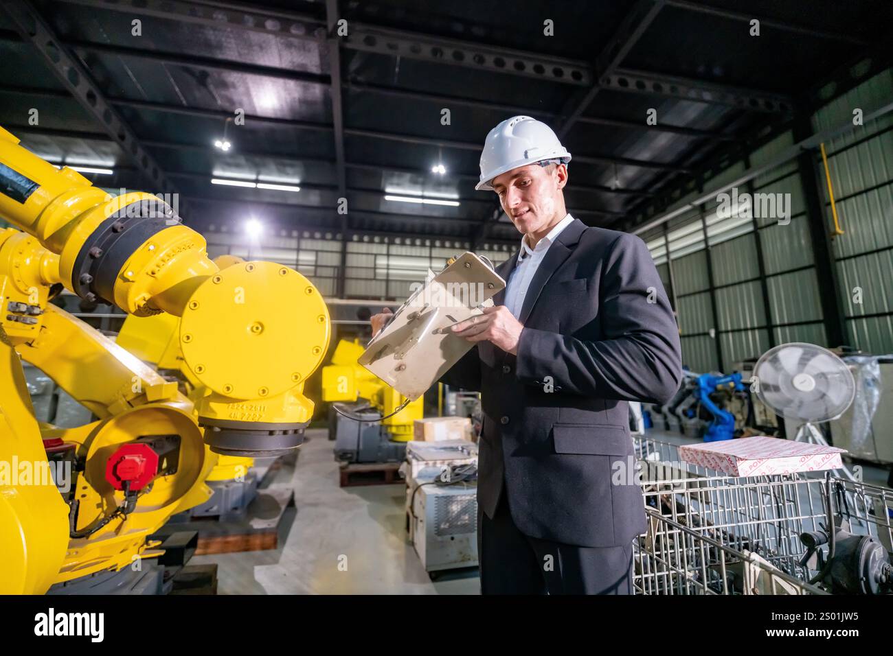 A professional engineer in formal attire examines a component while ...