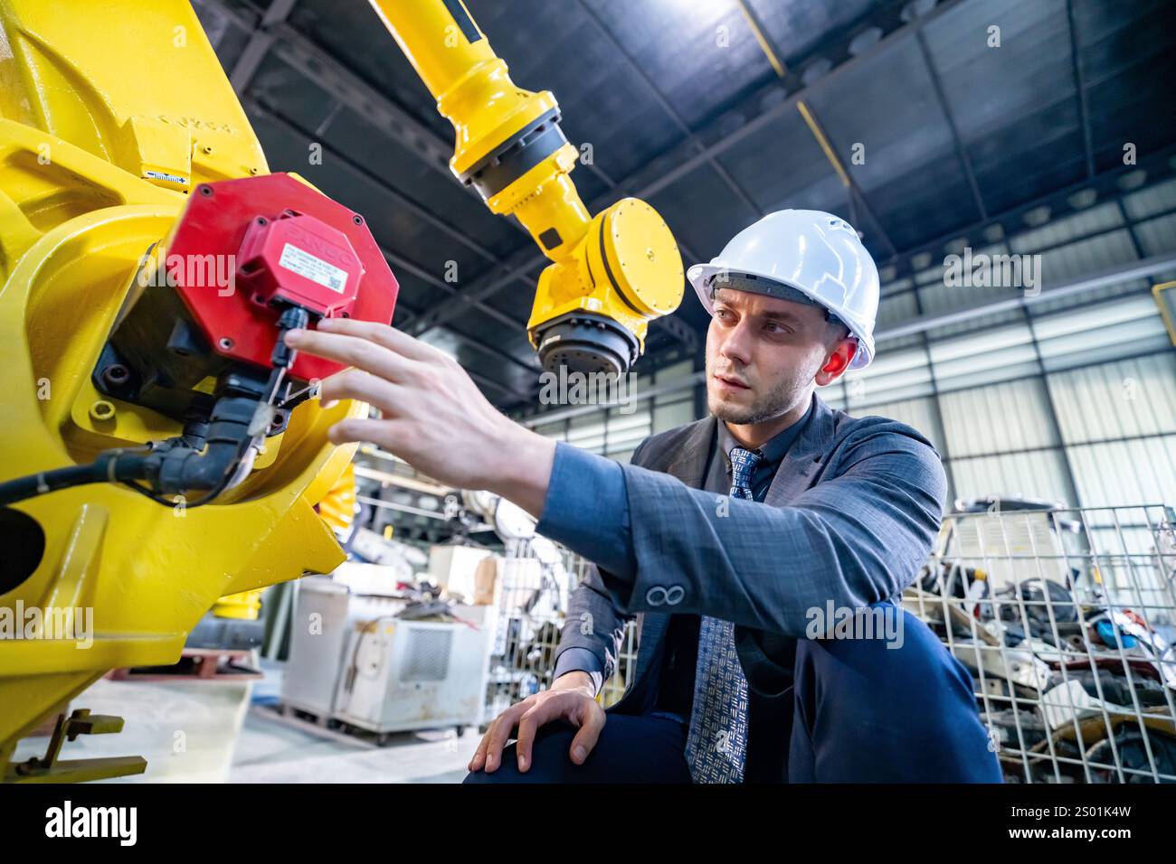 A professional engineer examines a robotic arm in a modern industrial ...