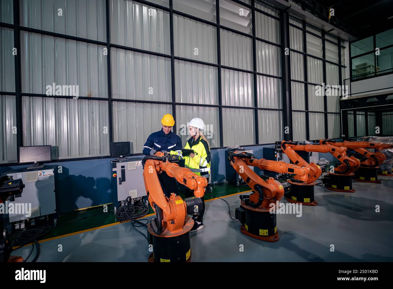 Two engineers discuss robotics systems in a high-tech industrial ...